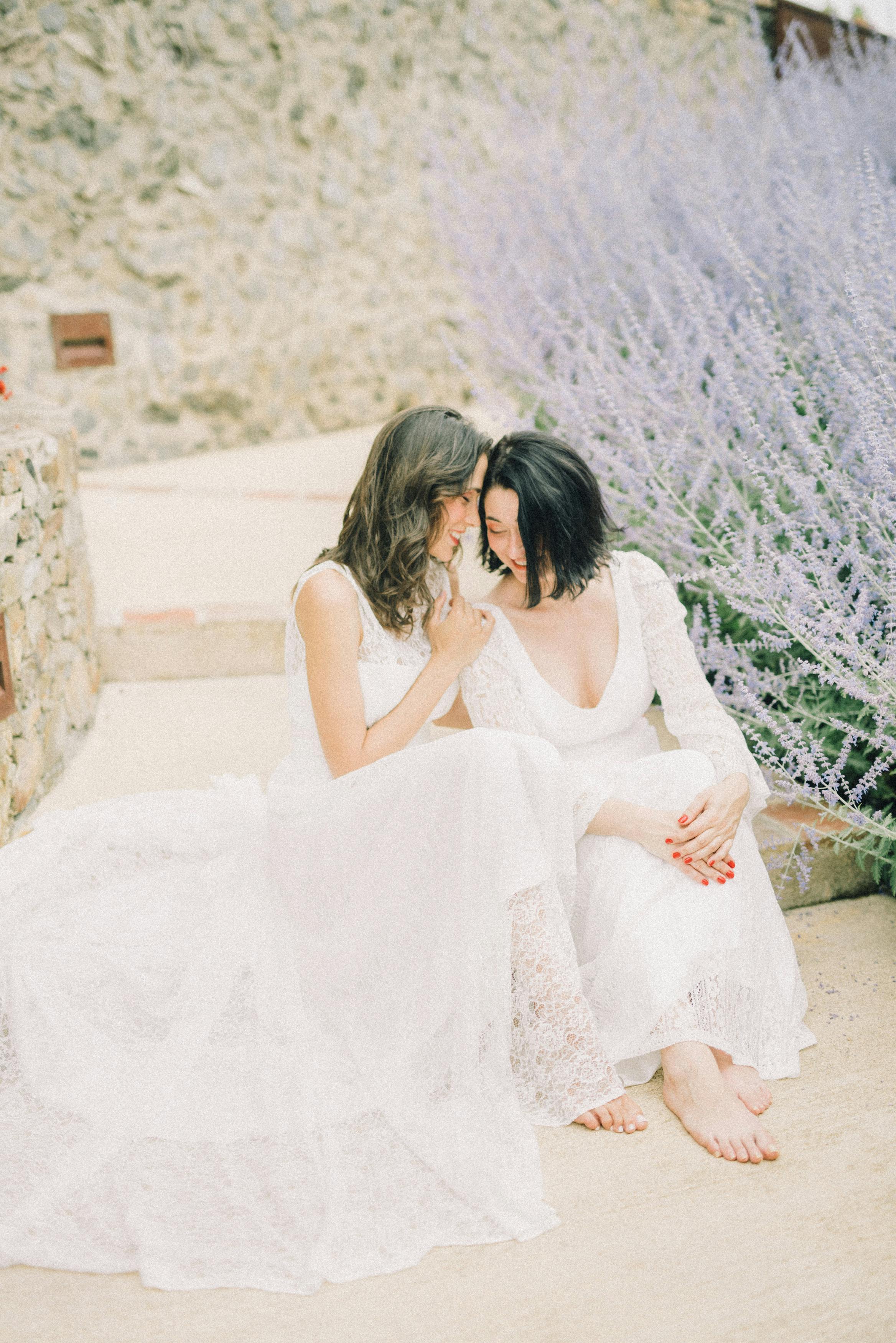 Woman in White Sleeveless Dress Sitting on Brown Concrete Wall · Free ...