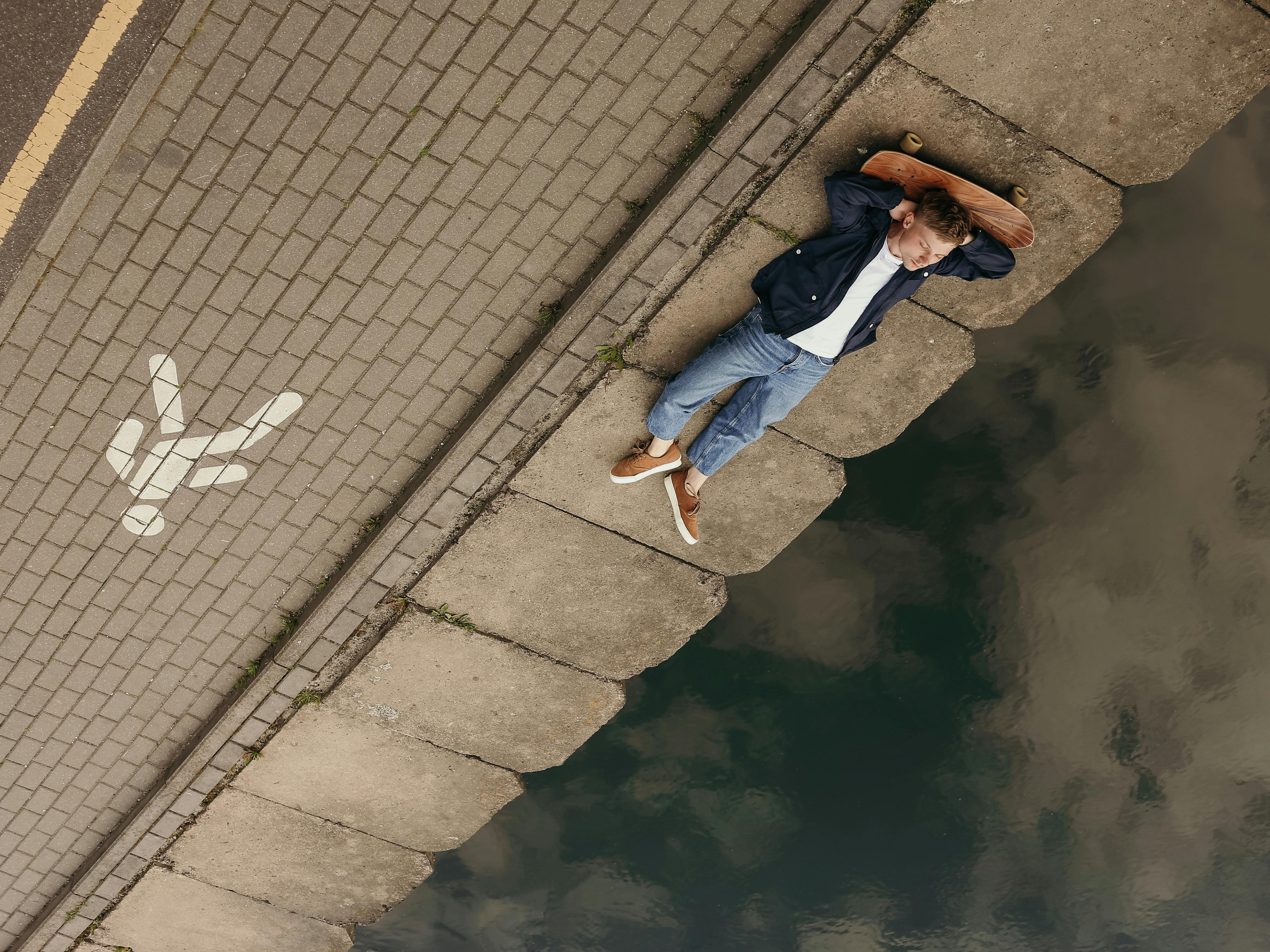 Photo of Man Lying on Concrete Floor · Free Stock Photo