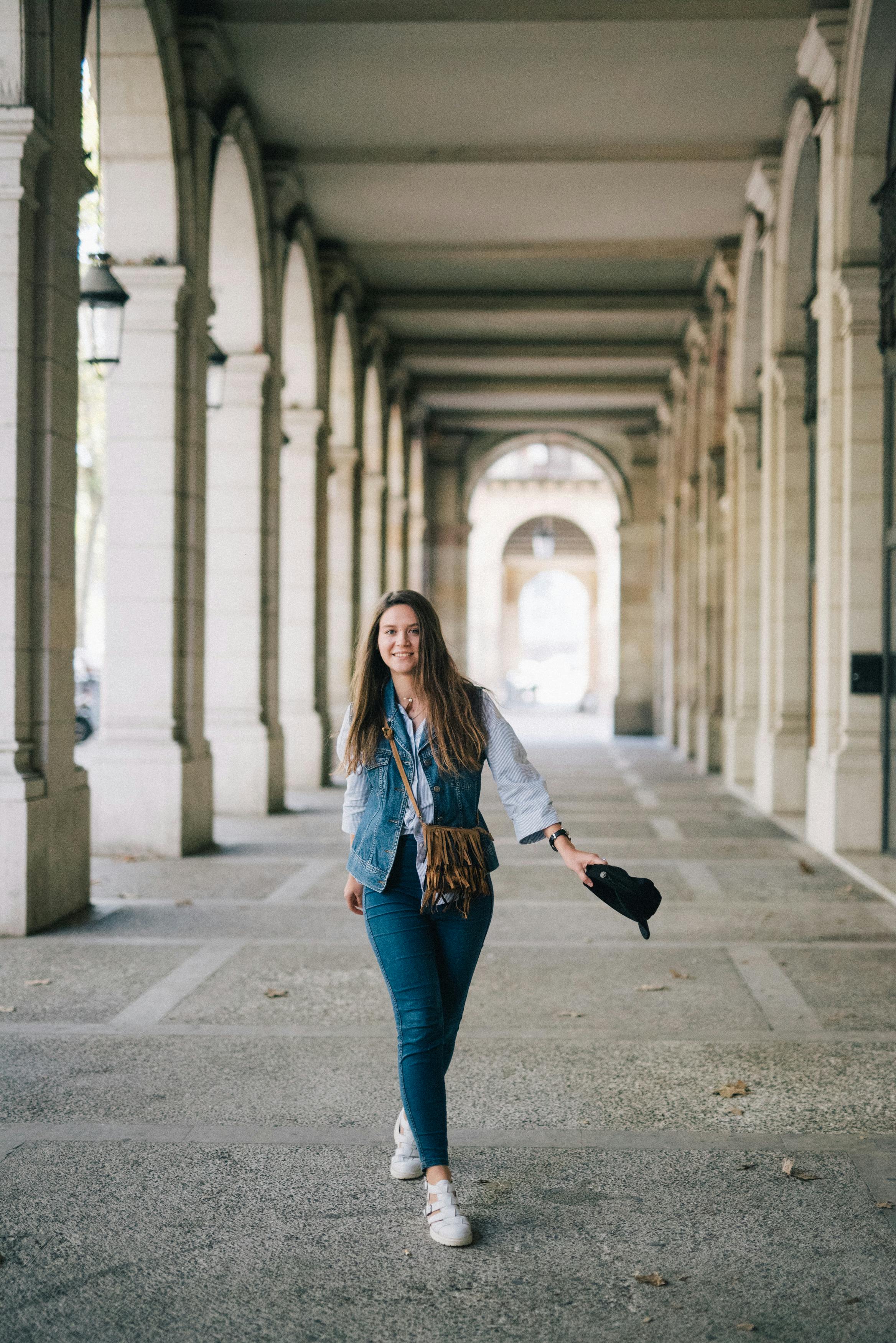 A Woman in Blue Denim Jeans Walking on the Street · Free Stock Photo