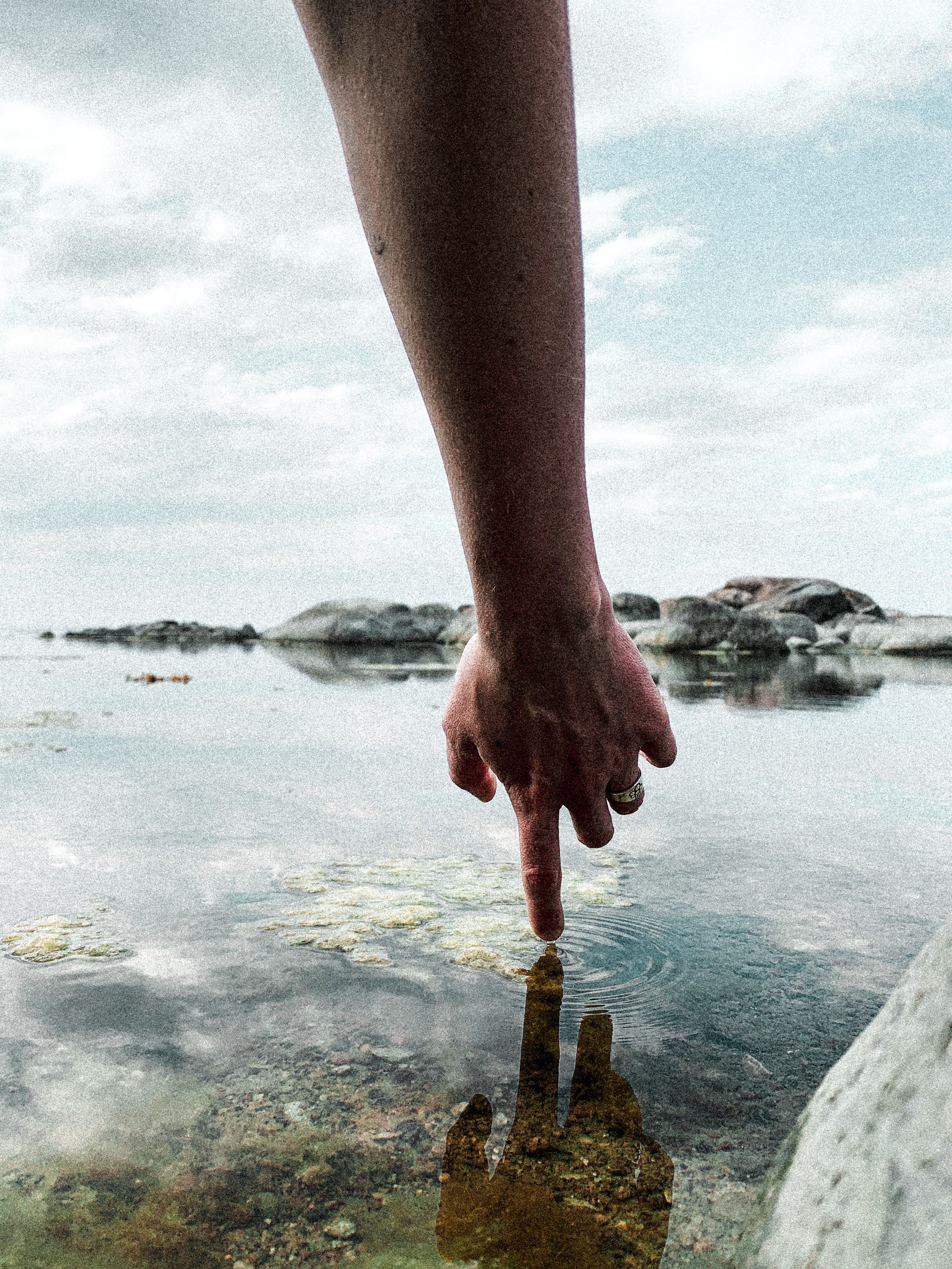 Crop person touching calm water surface · Free Stock Photo