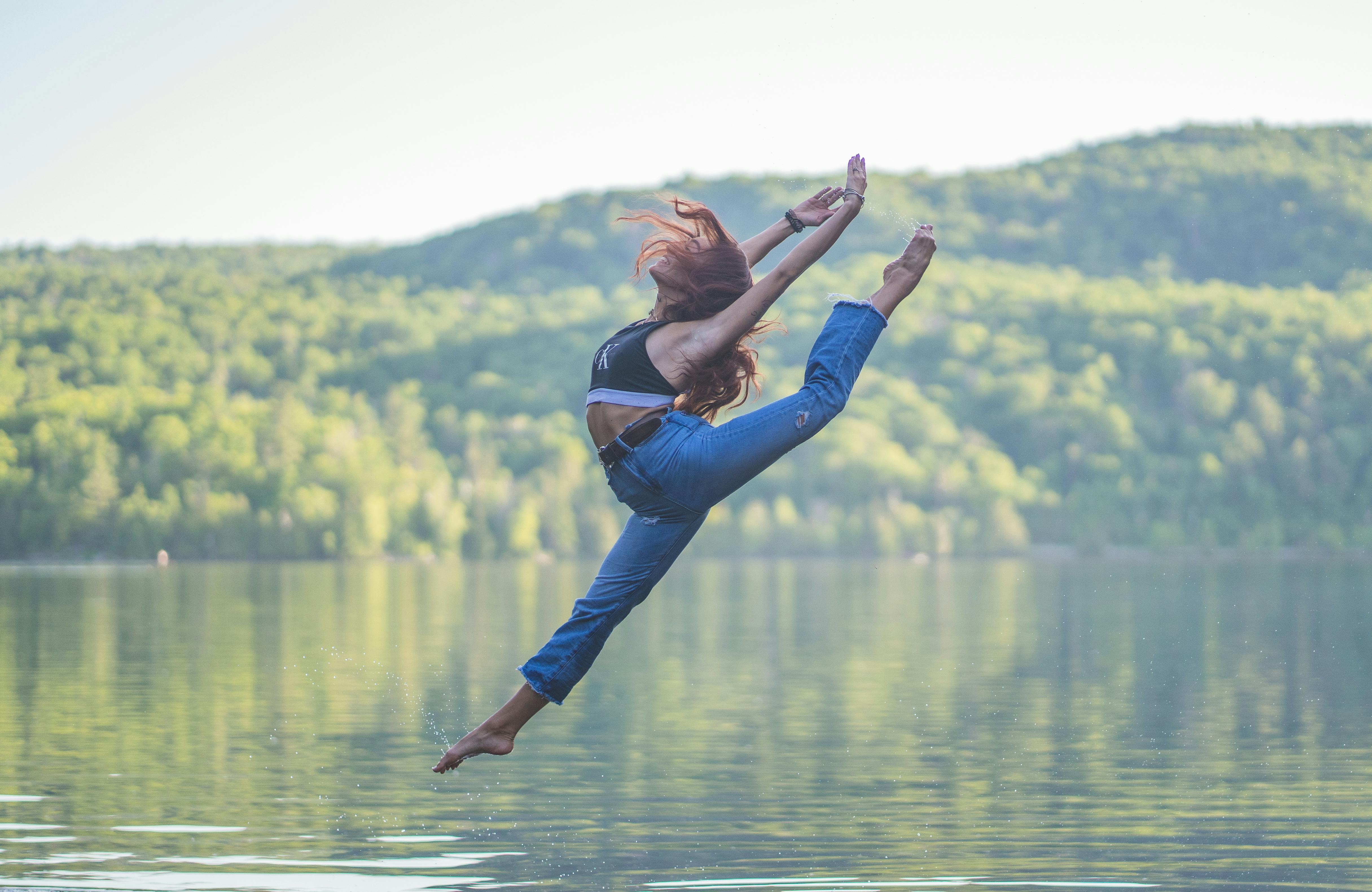 Woman jumping and doing splits in nature · Free Stock Photo