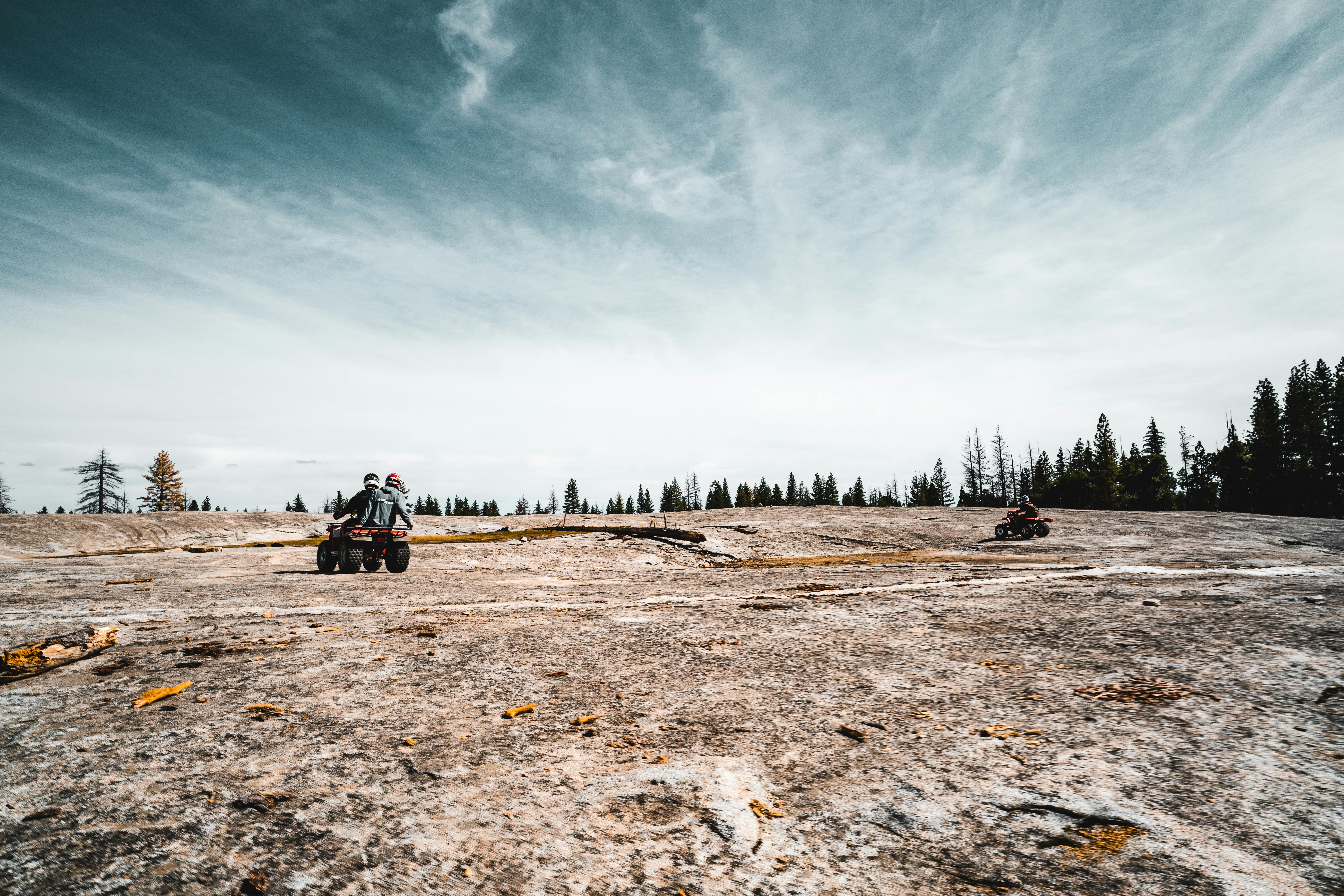 People Riding on Quad Bikes in a Field · Free Stock Photo
