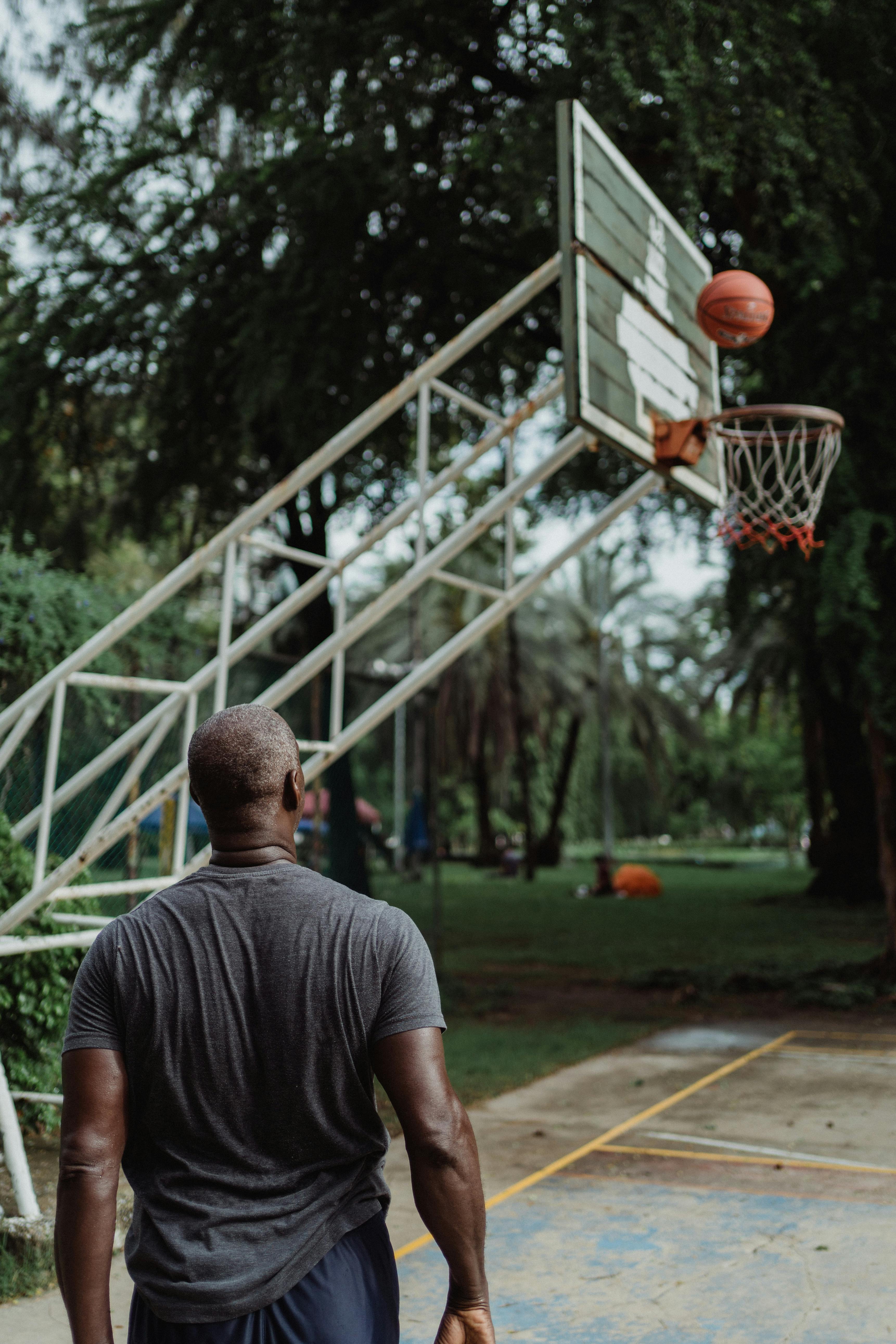 Man Looking at Flying Basketball Ball · Free Stock Photo