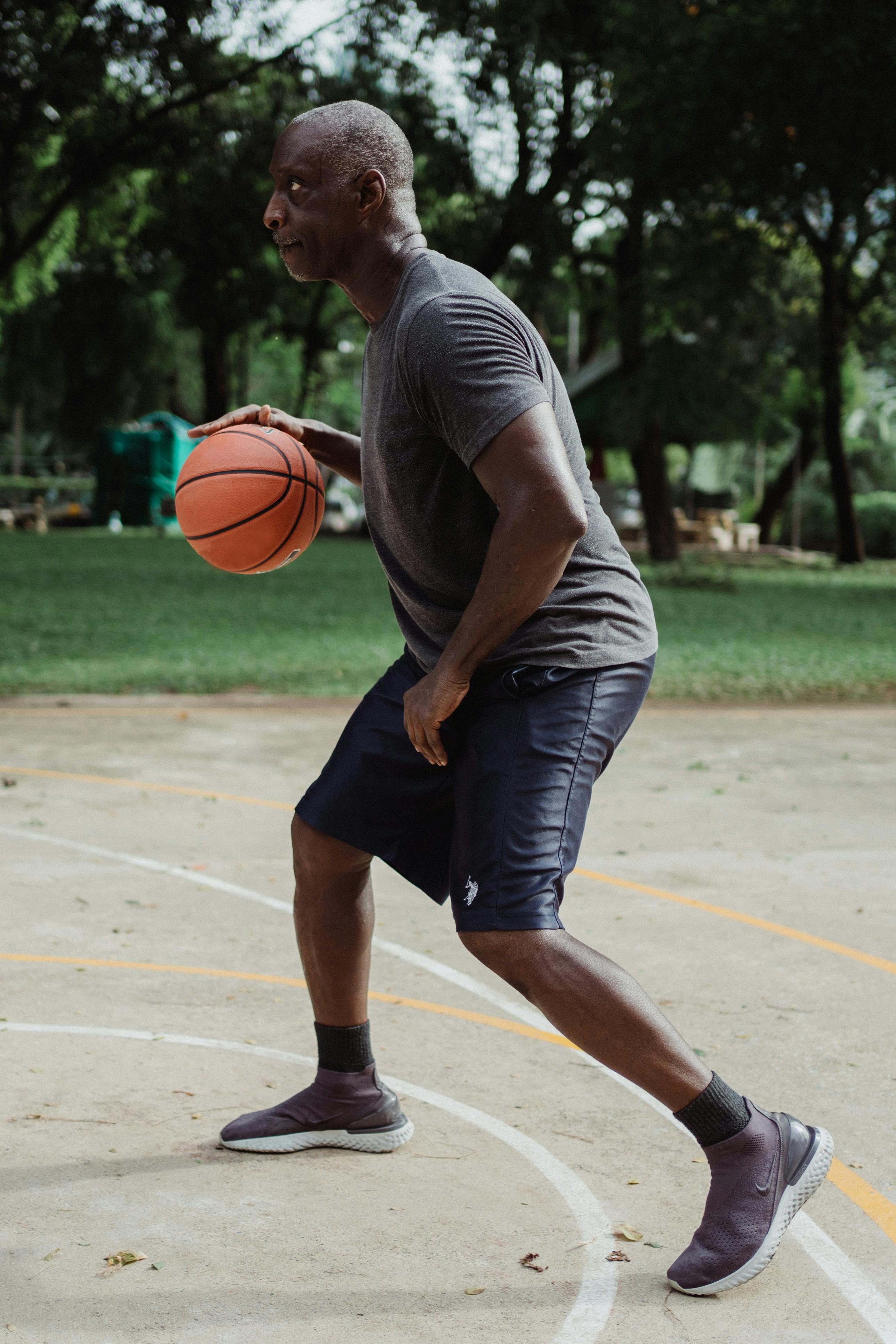 A Man in Gray Shirt Playing Basketball · Free Stock Photo