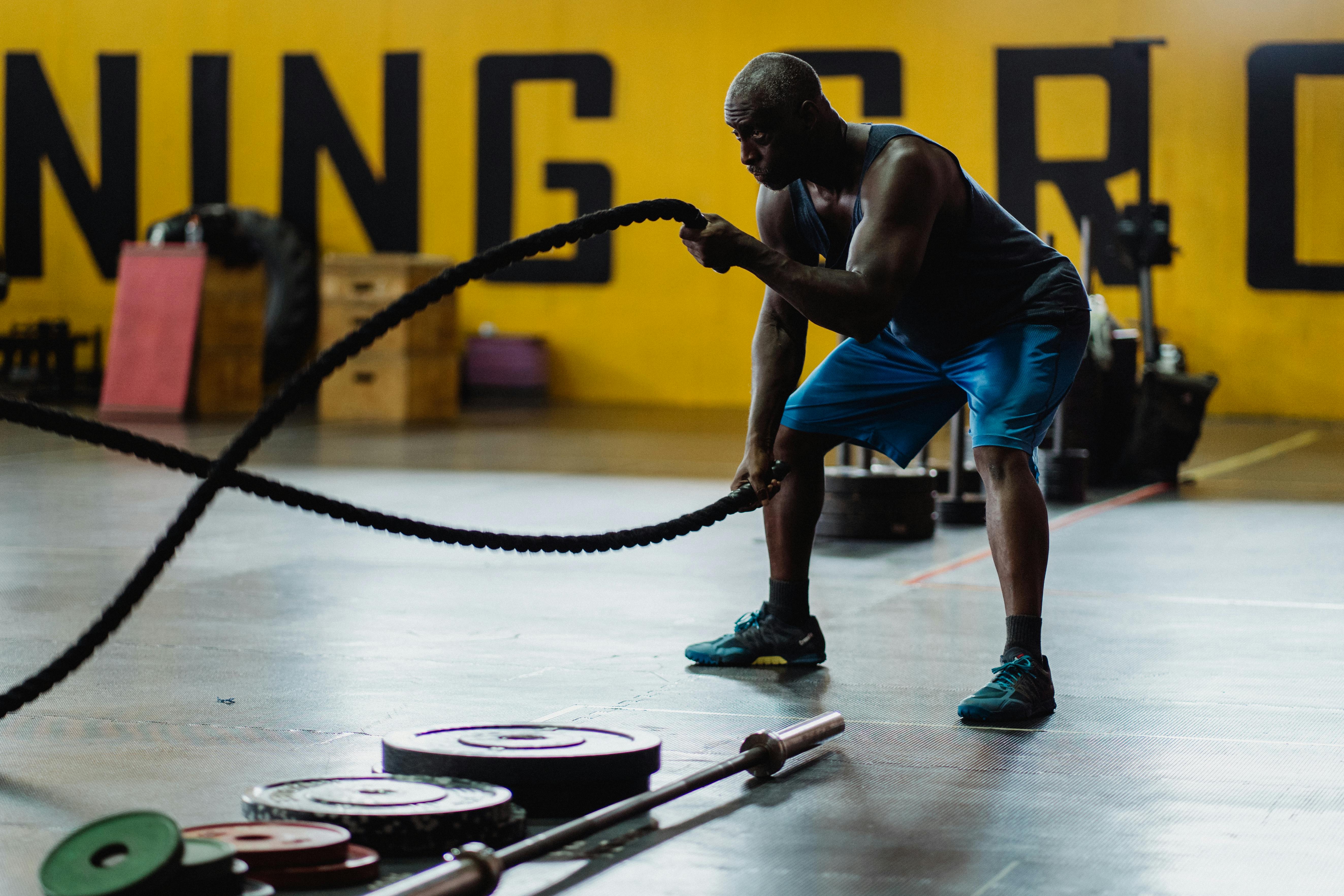 Man in Blue Shorts Doing Exercise with Ropes · Free Stock Photo