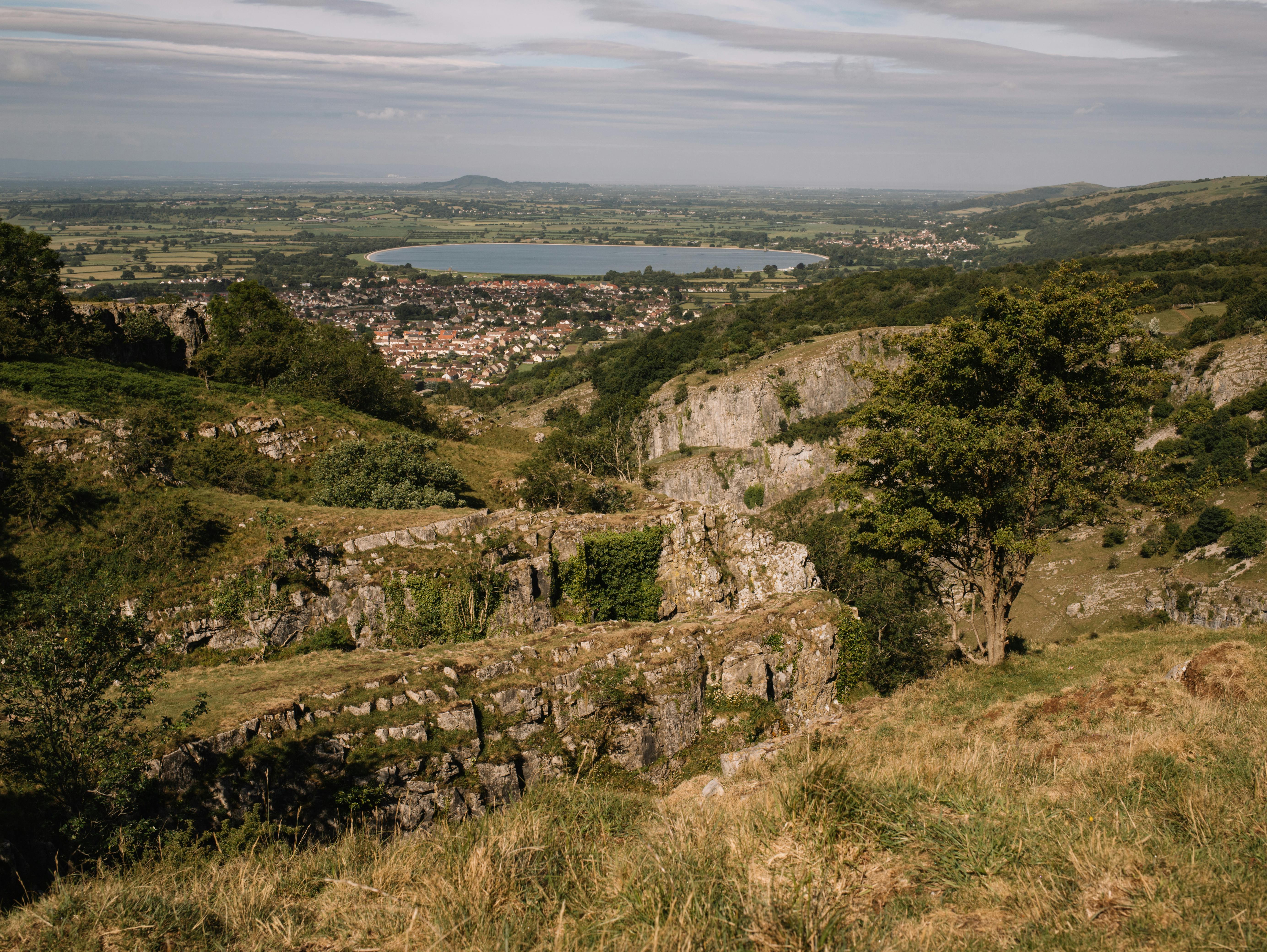 Green rocky cliff near blue lake · Free Stock Photo
