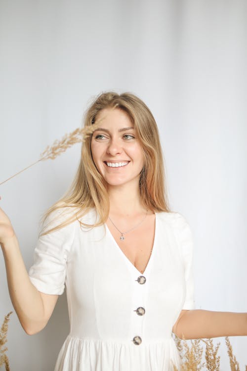 Woman Wearing White Tank Top Taking Picture Against Green Leaf Plant
