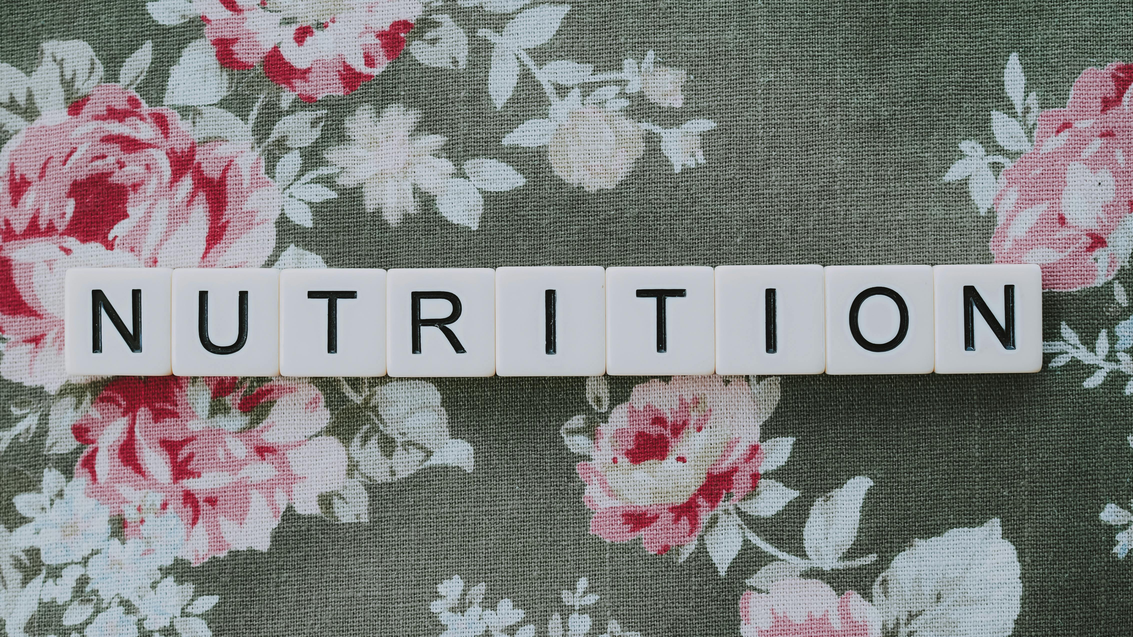 A Word Nutrition Spelled with White Letter Blocks on a Floral Textile ...