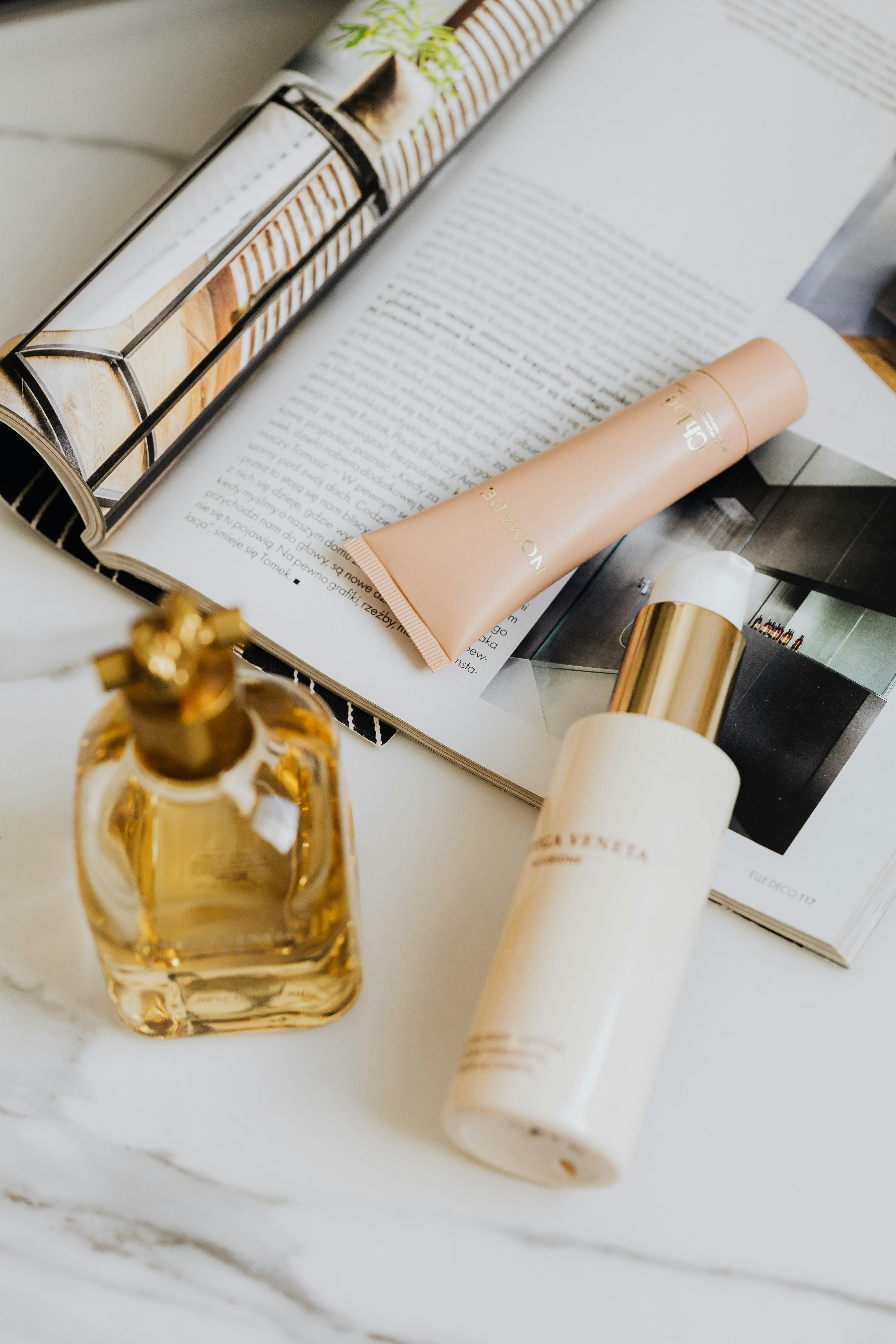 Perfume and Cosmetics Lying on a Fashion Magazine · Free Stock Photo