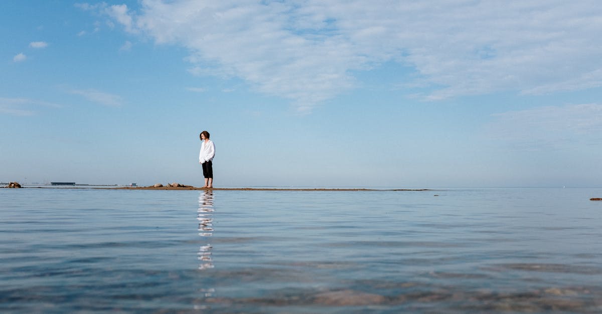 Woman In White Long Sleeve Shirt And Black Skirt Standing On Water