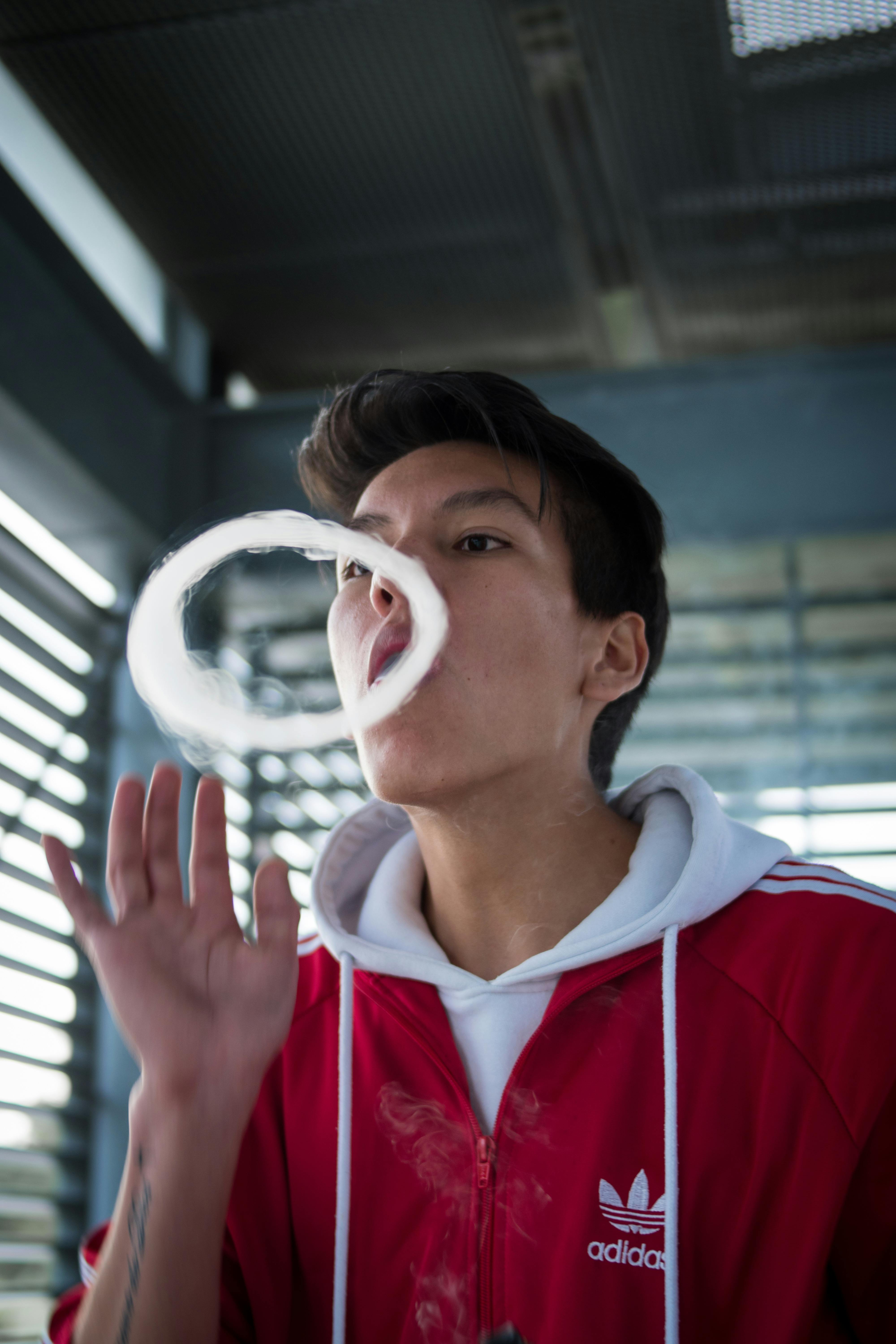 Man Sitting on Ground Smoking Vape · Free Stock Photo
