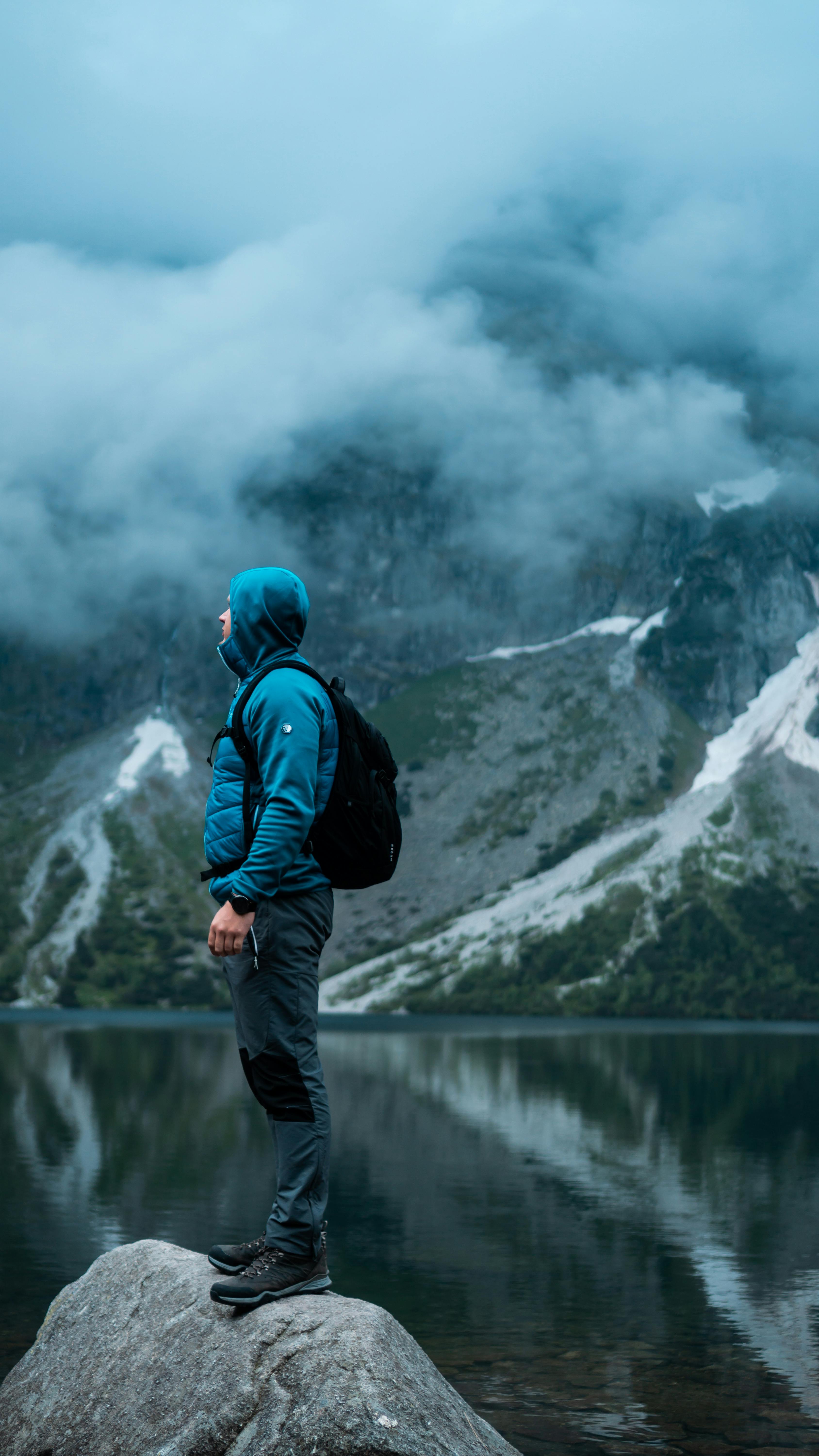 Man in Blue Jacket Standing on a Rock · Free Stock Photo