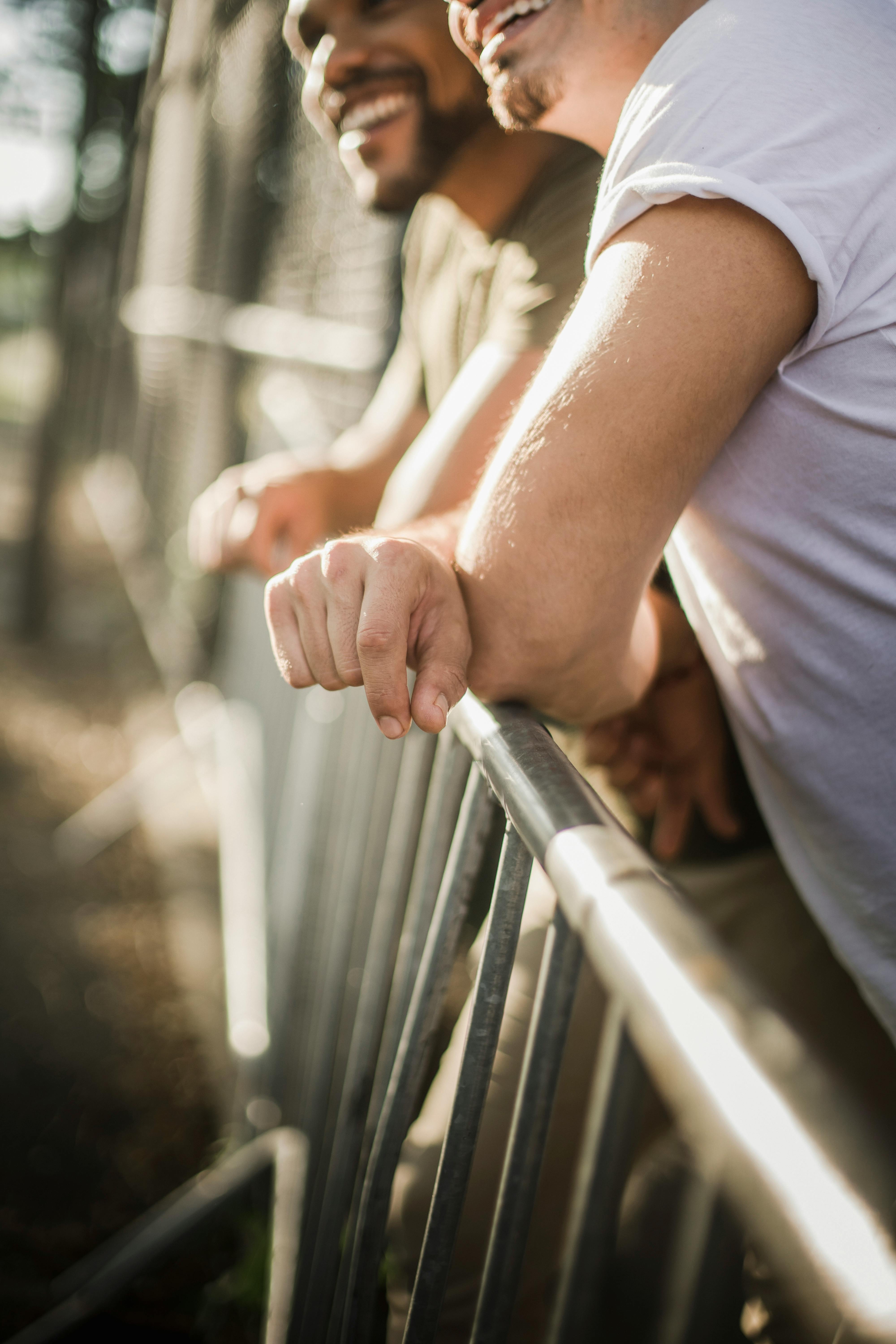 Two Men Resting Their Arms on a Railing · Free Stock Photo