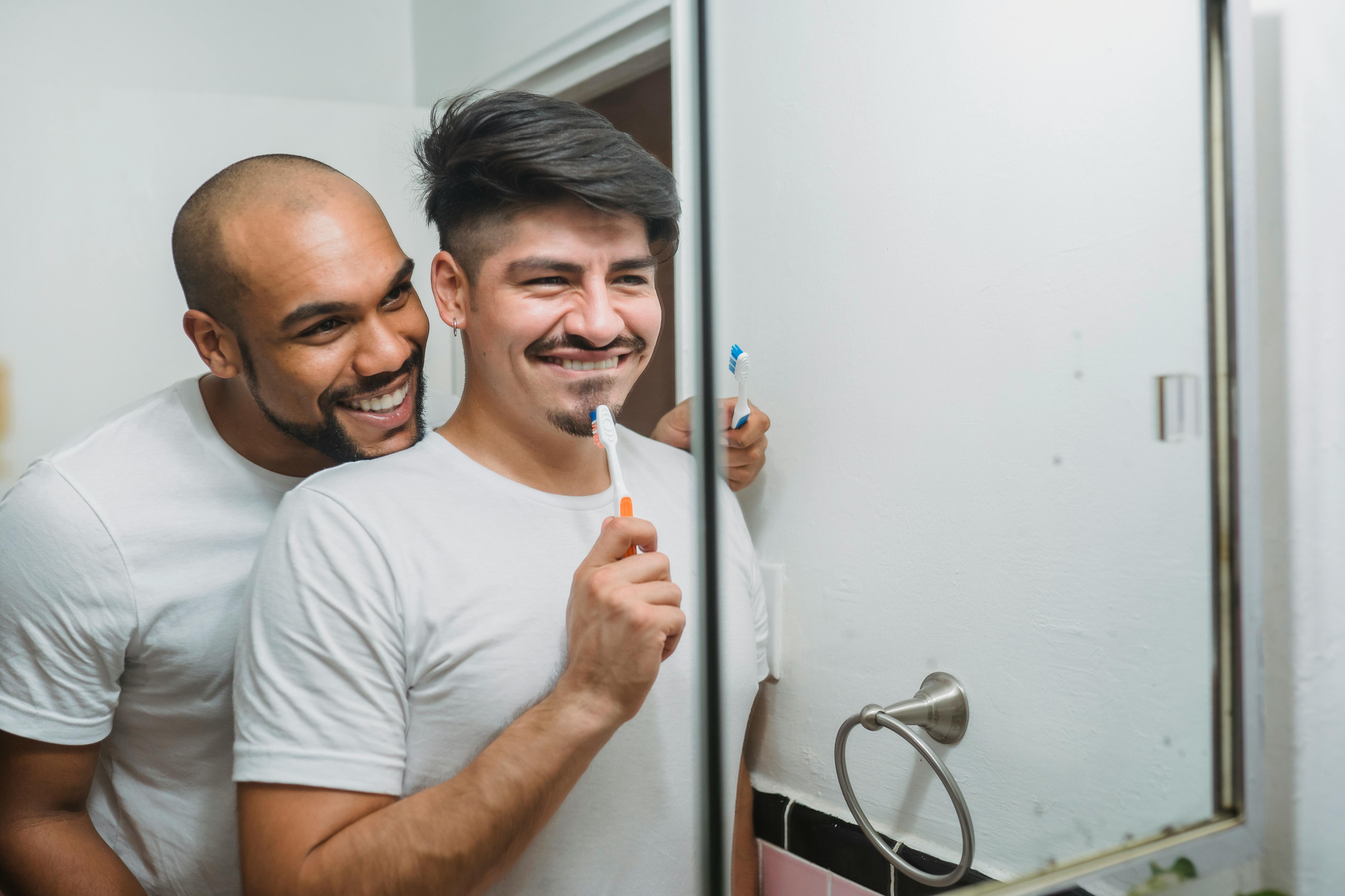 A Happy Couple Brushing their Teeth Together · Free Stock Photo