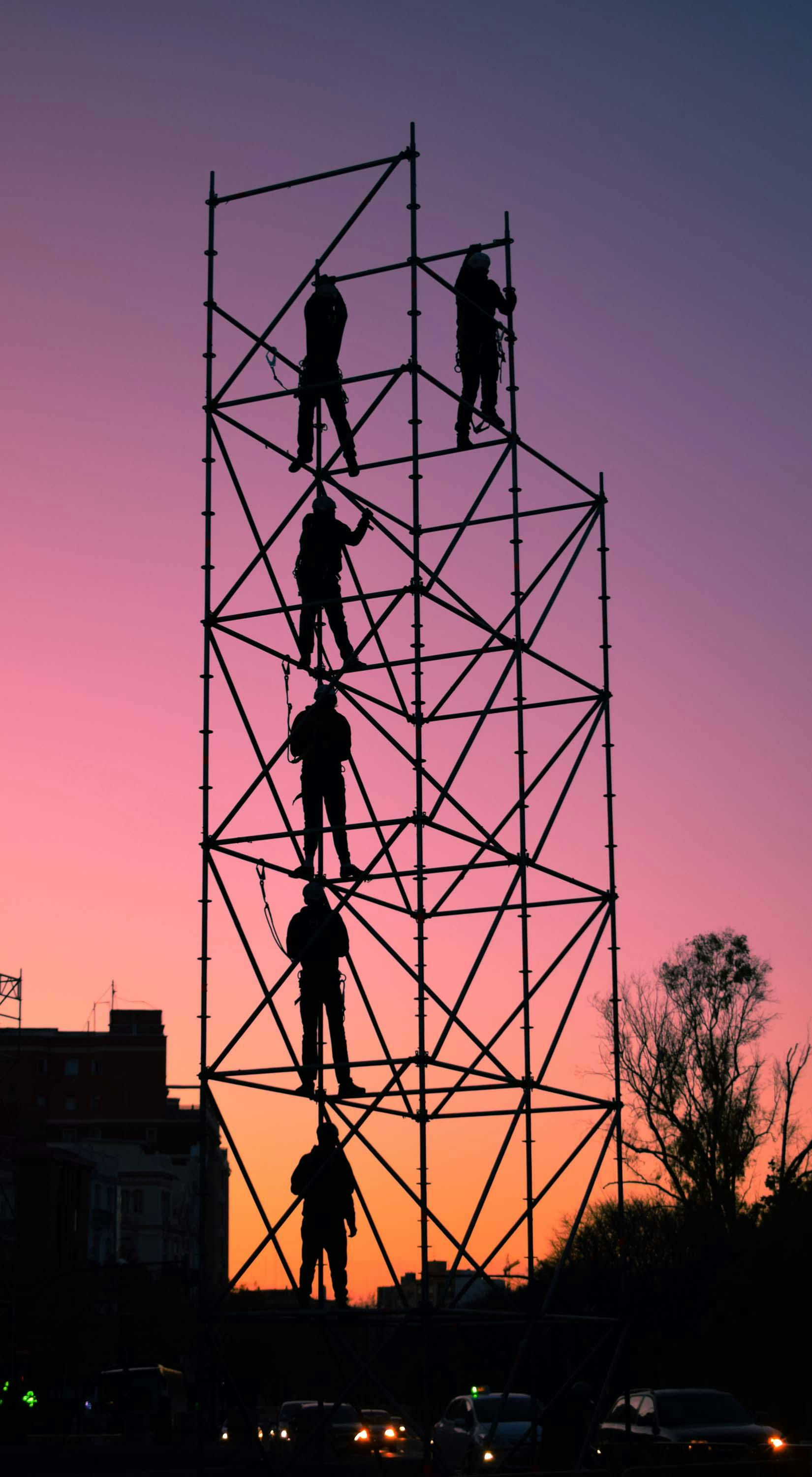 People On A Scaffolding Under A Purple Sky · Free Stock Photo