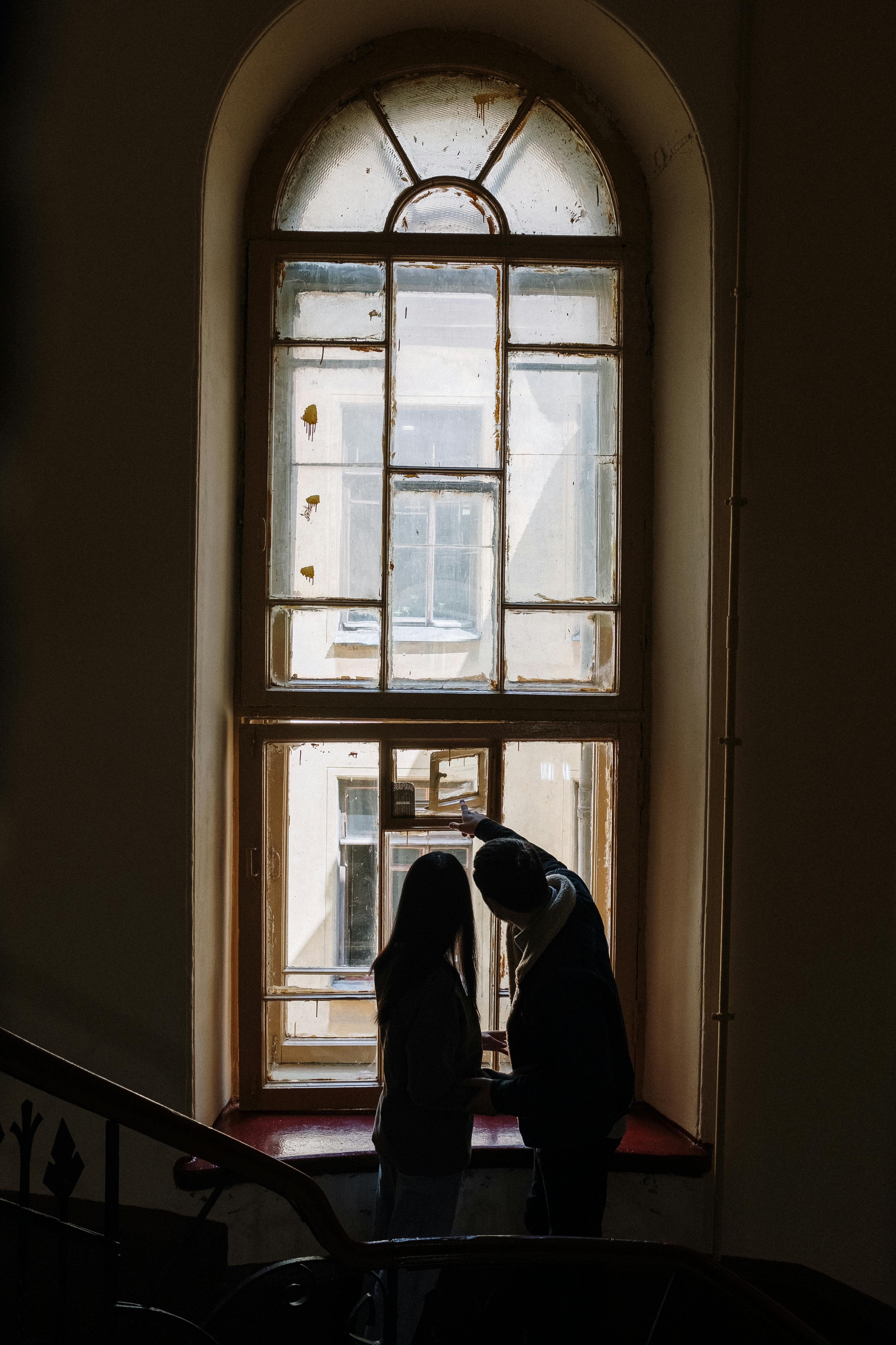 Man in Black Jacket Standing Beside Window · Free Stock Photo