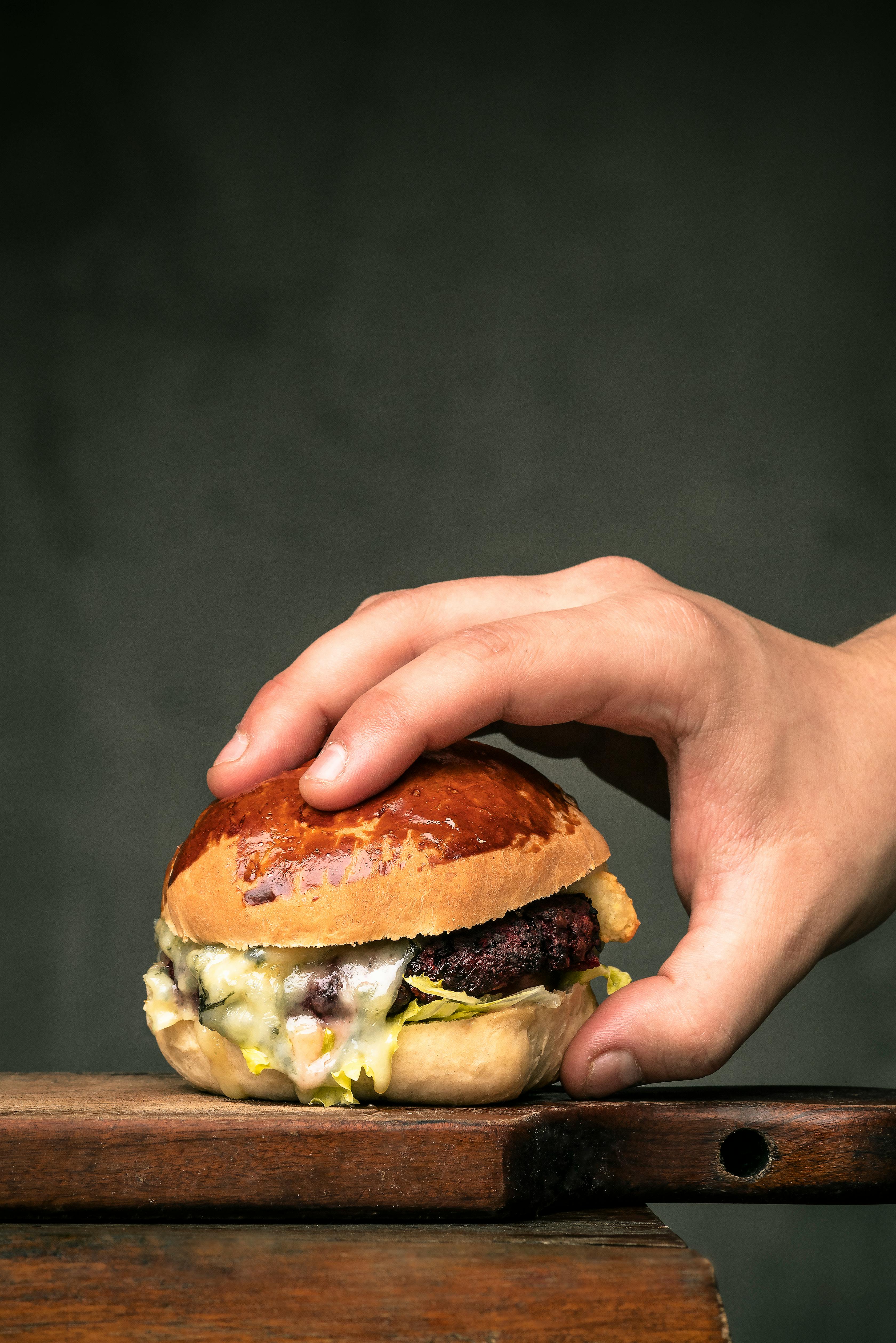 Hand Holding a Burger · Free Stock Photo
