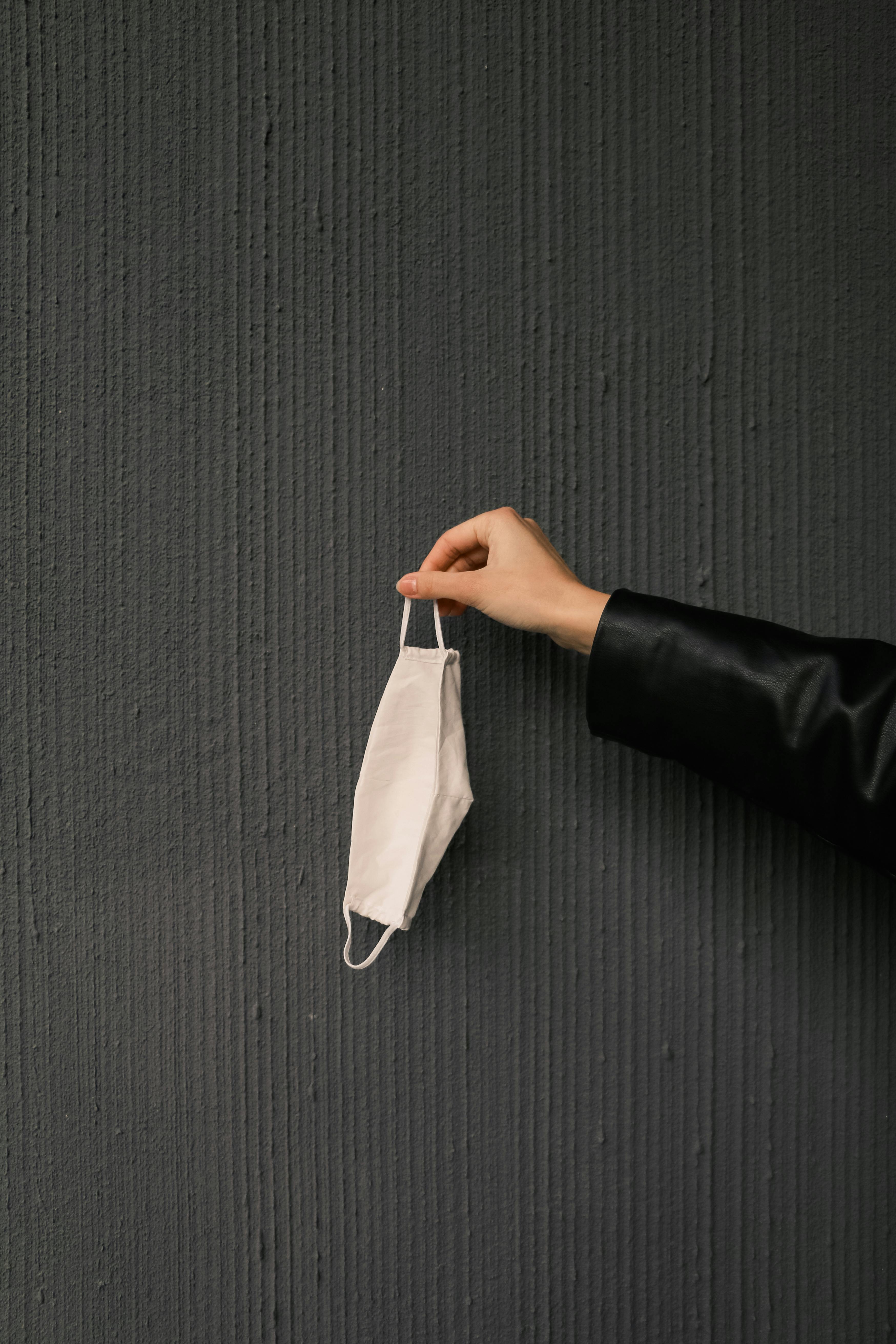 Hand Holding a White Face Mask · Free Stock Photo