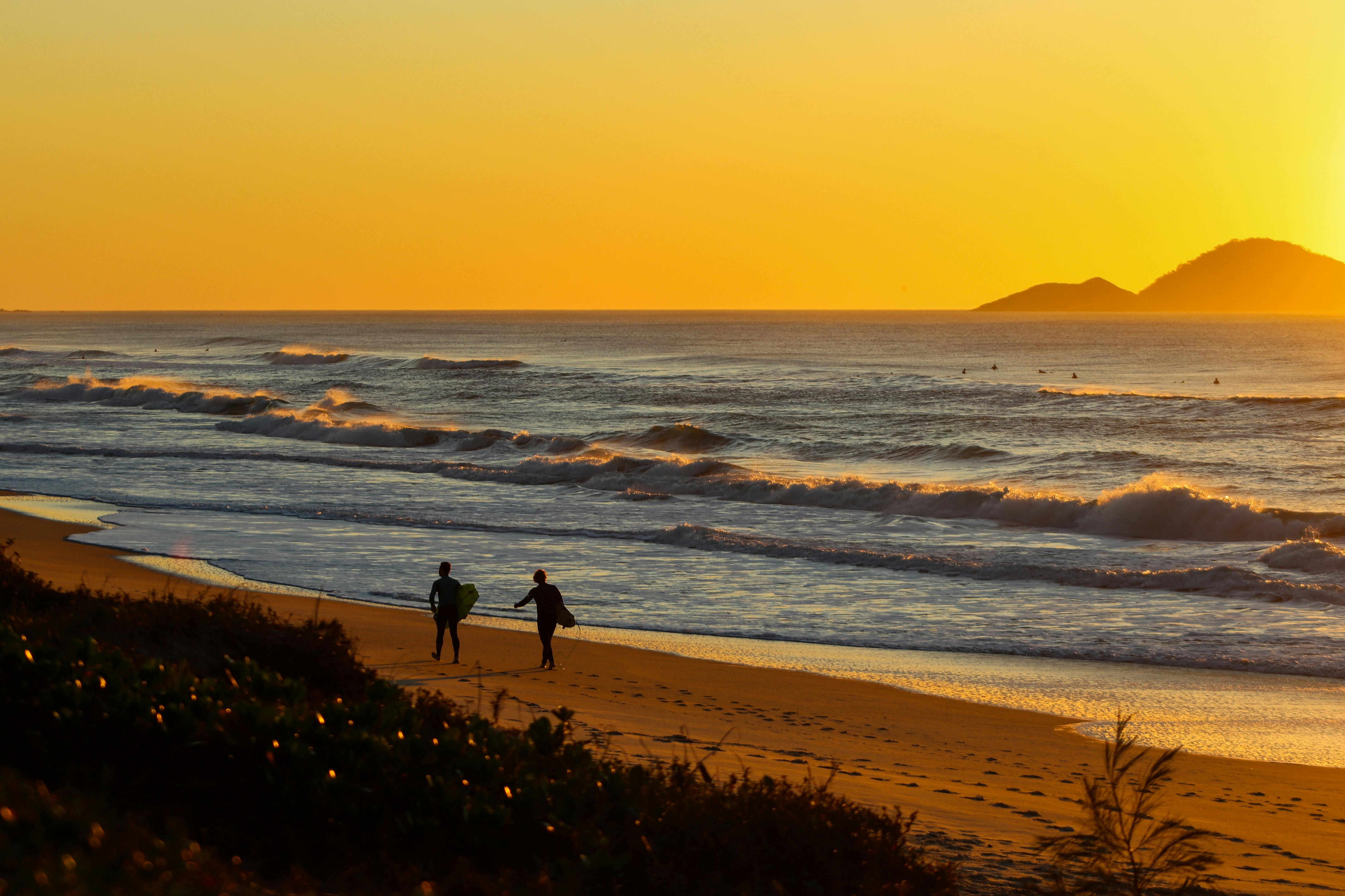 Woman in Yellow Jacket and Yellow Hat Standing on Black Sand · Free ...