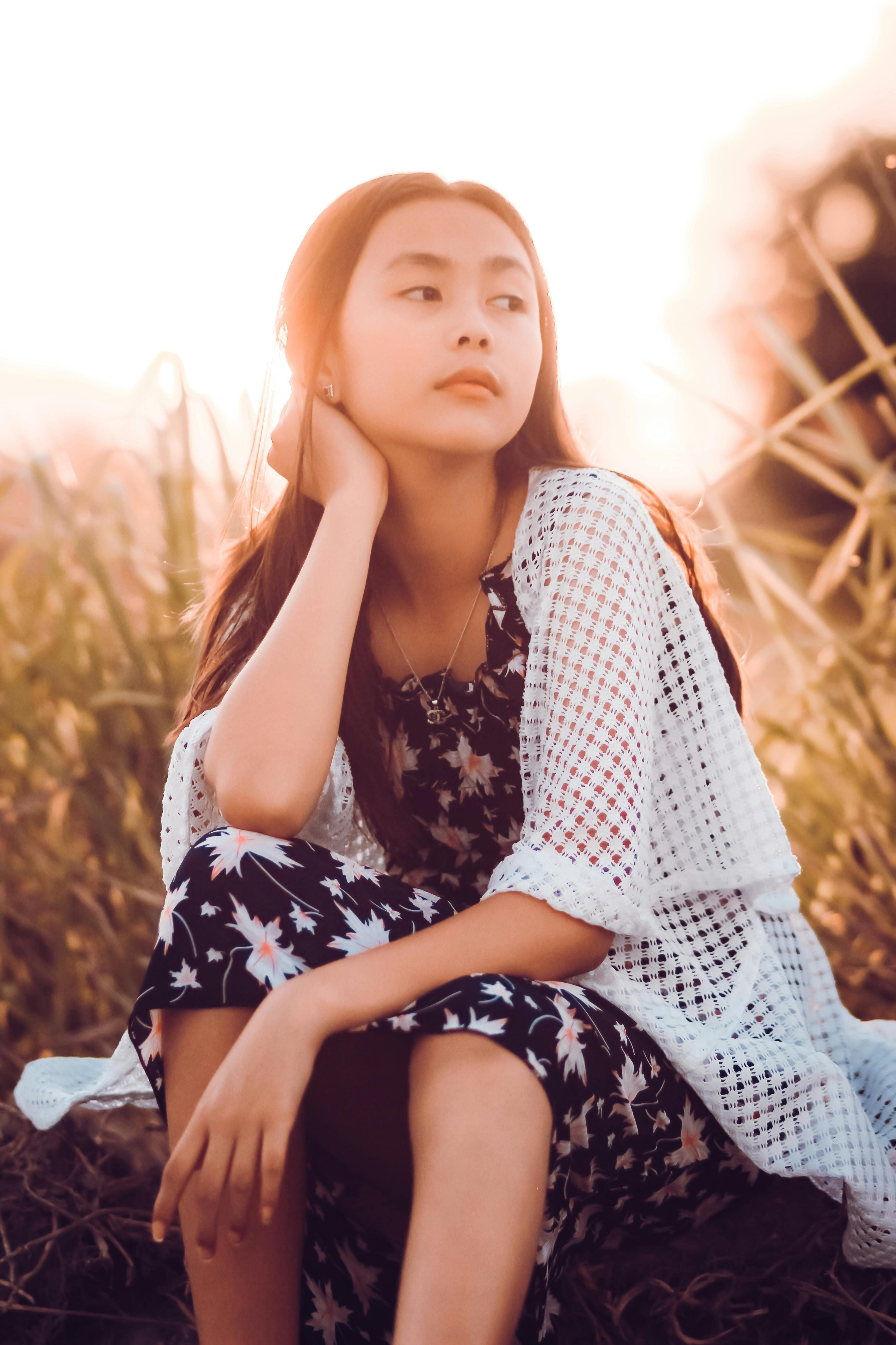 Girl in Traditional Costume Sitting Outdoors with Toy · Free Stock Photo