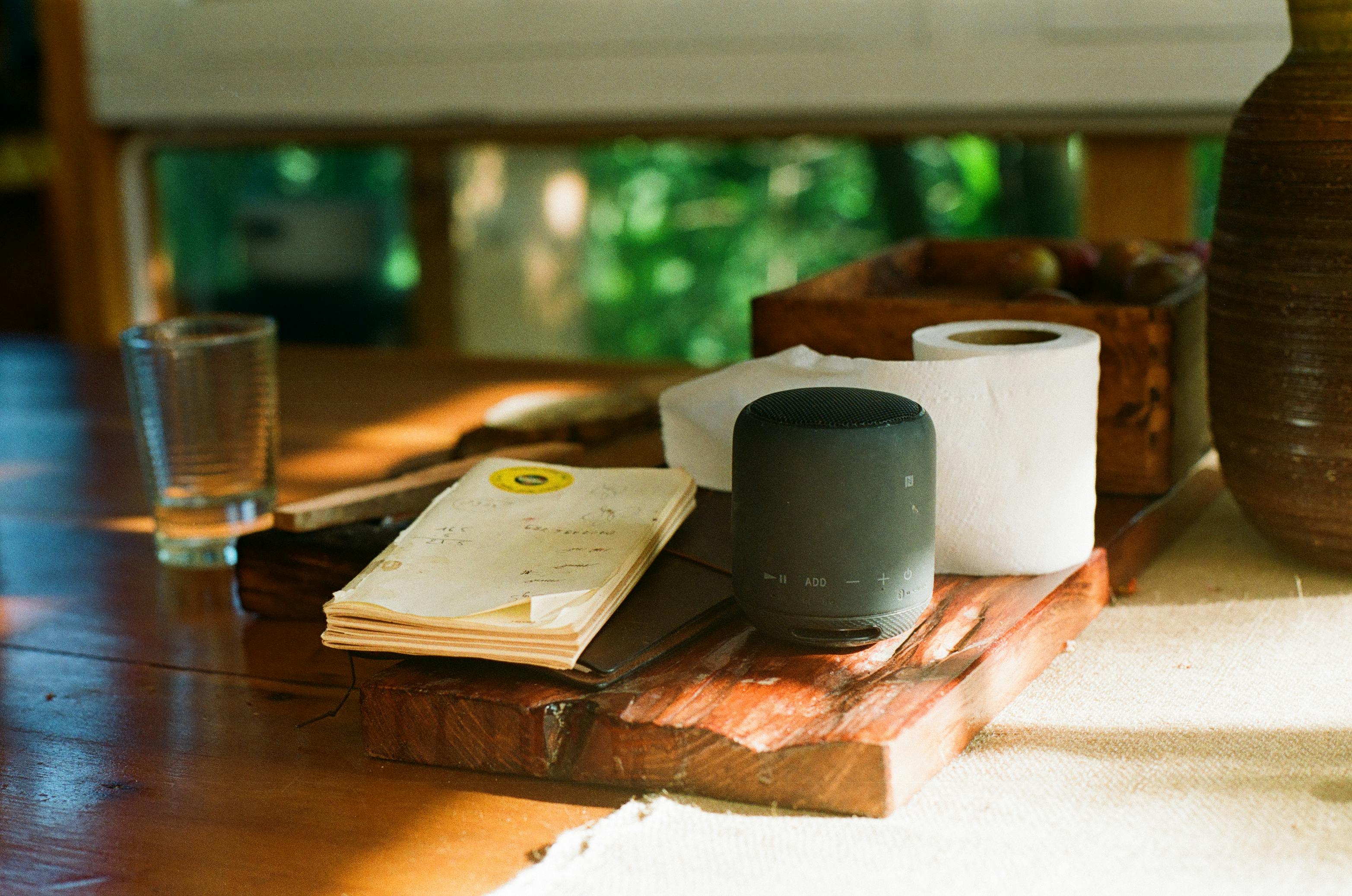 Toilet Paper, Camera Lens and Book on Wood · Free Stock Photo