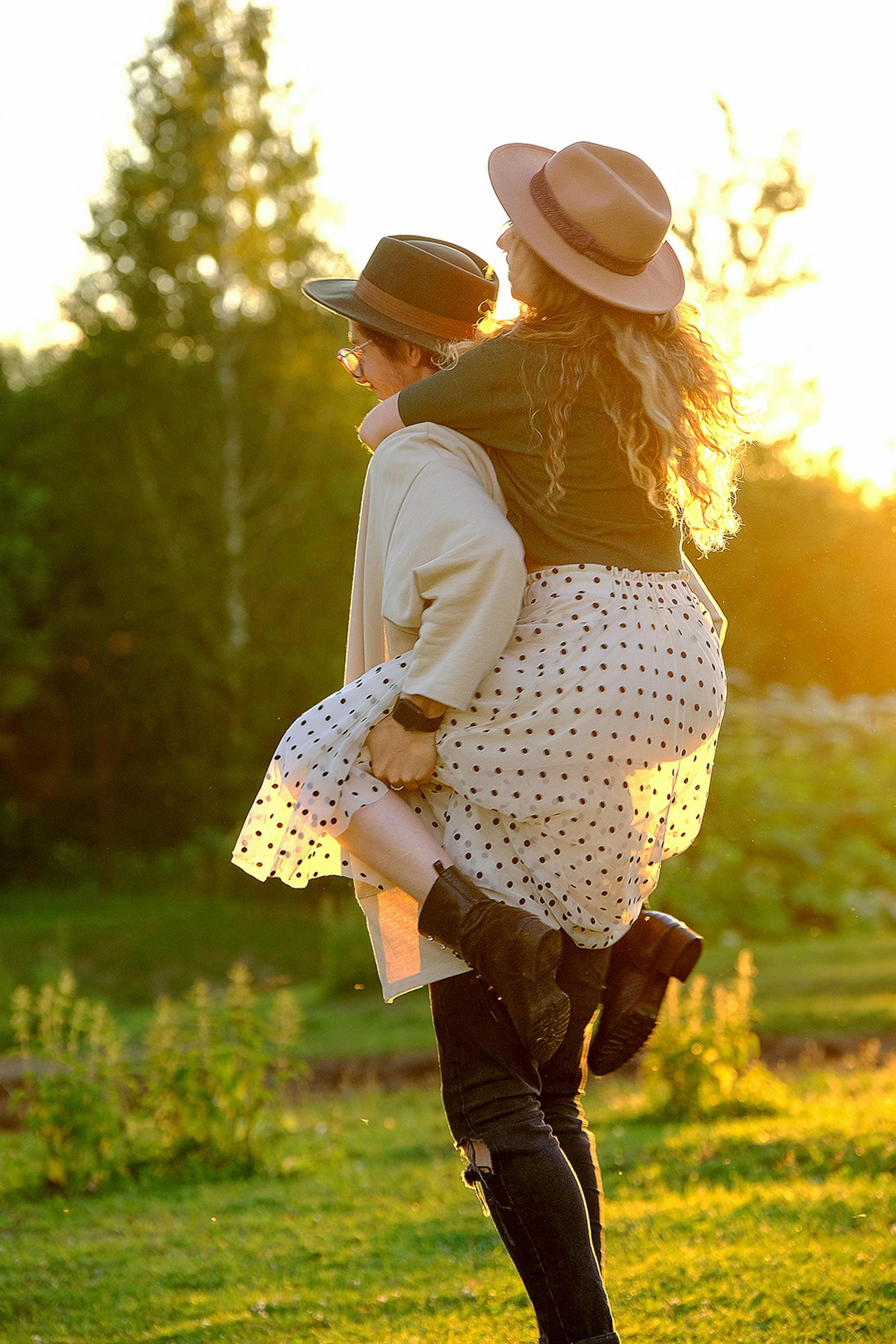 Happy young guy carrying girlfriend on back during romantic date in ...
