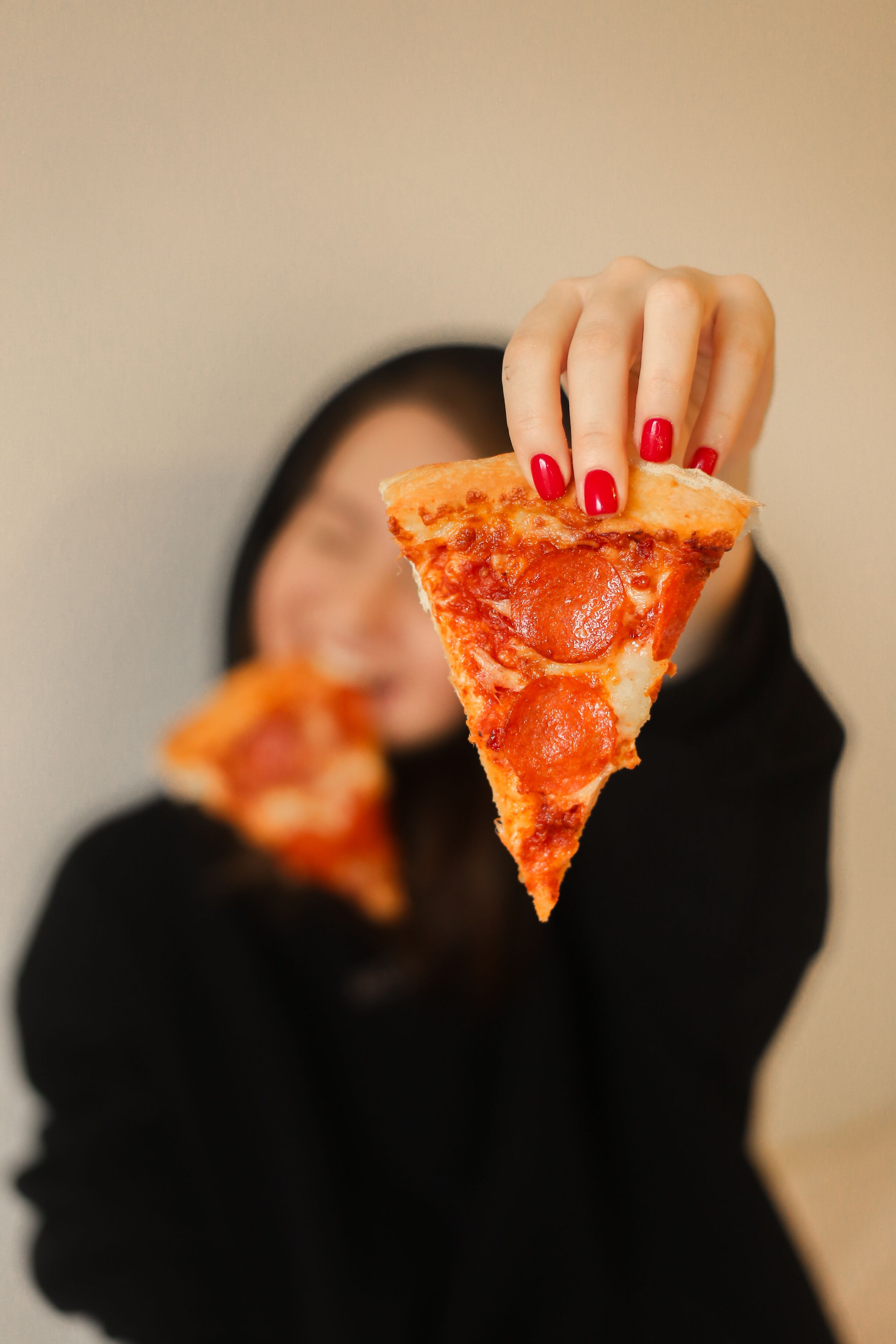 Person Holding a Slice of Pizza · Free Stock Photo