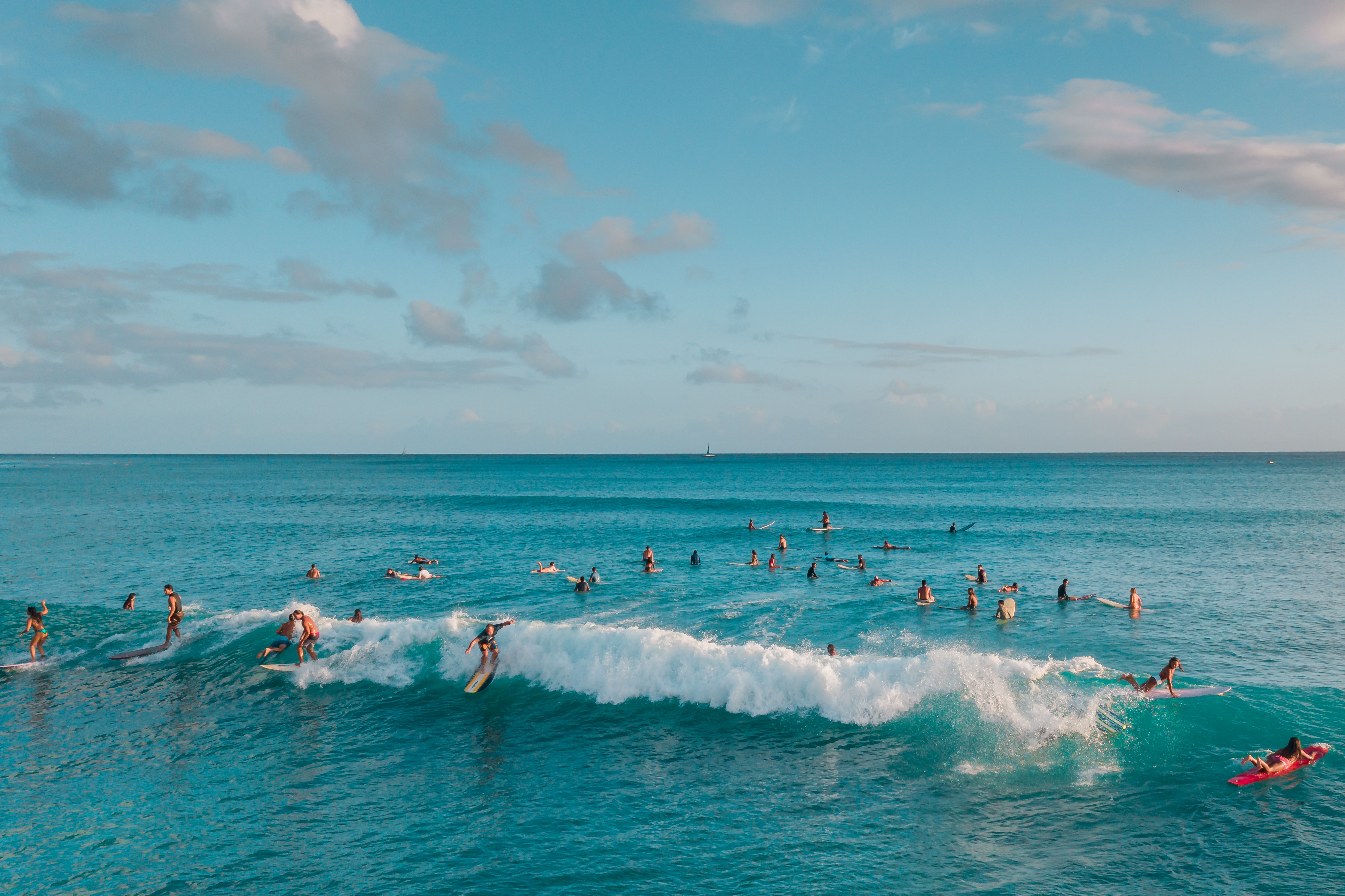 People Surfing on Sea Under a Blue Sky · Free Stock Photo