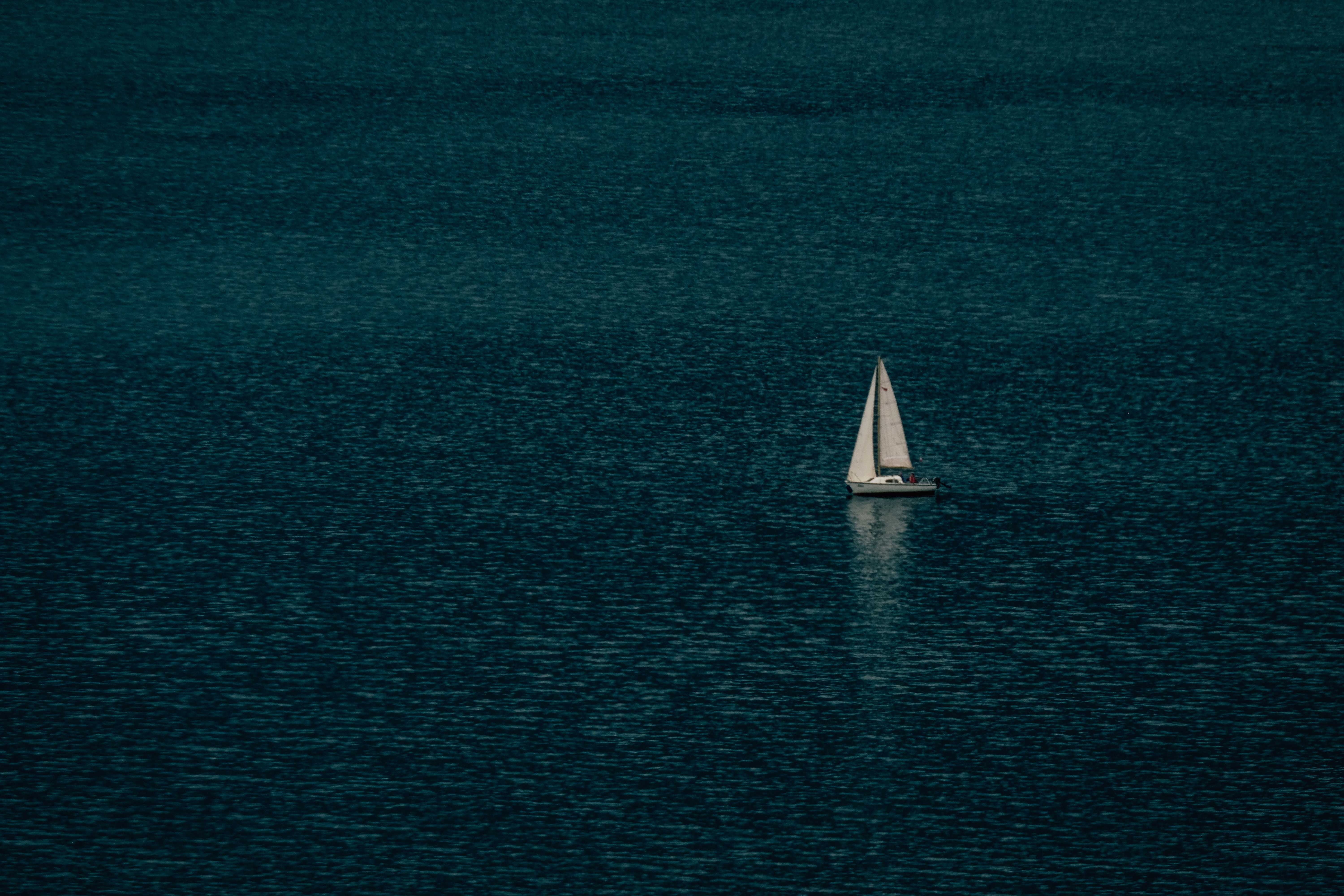 Lonesome sailboat floating on rippling sea · Free Stock Photo