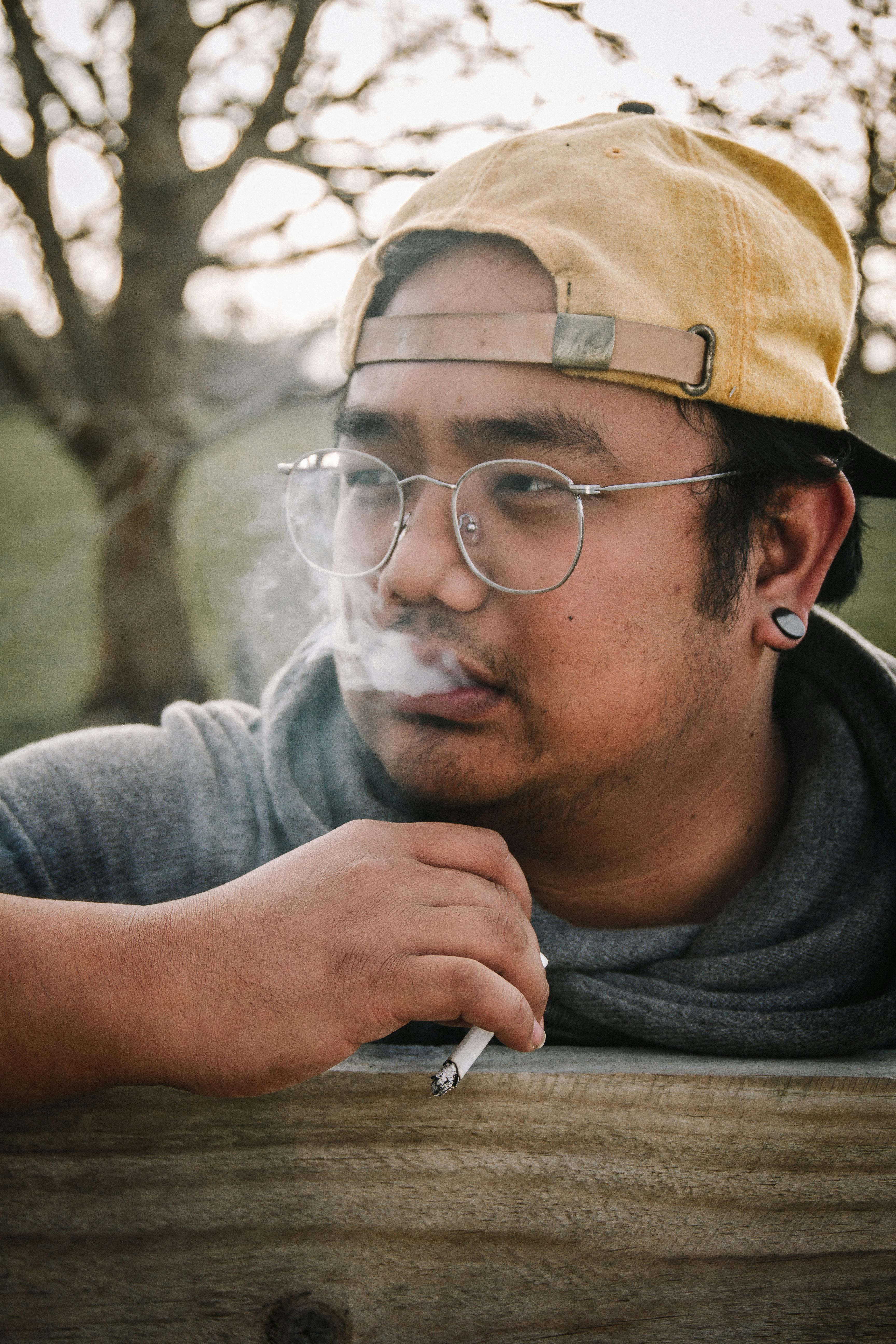 Man Sitting on Ground Smoking Vape · Free Stock Photo