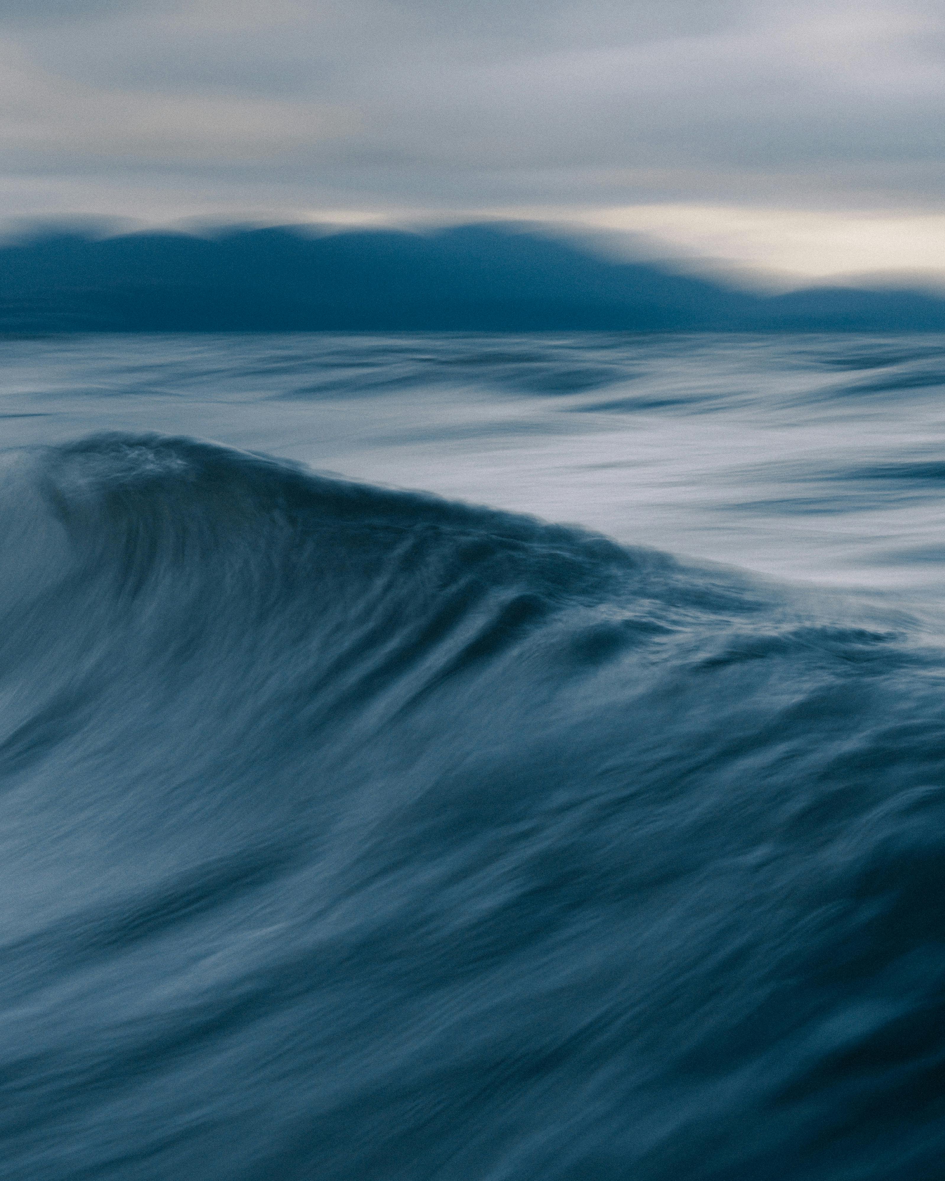 Rapid wave on stormy sea behind ridge in twilight · Free Stock Photo