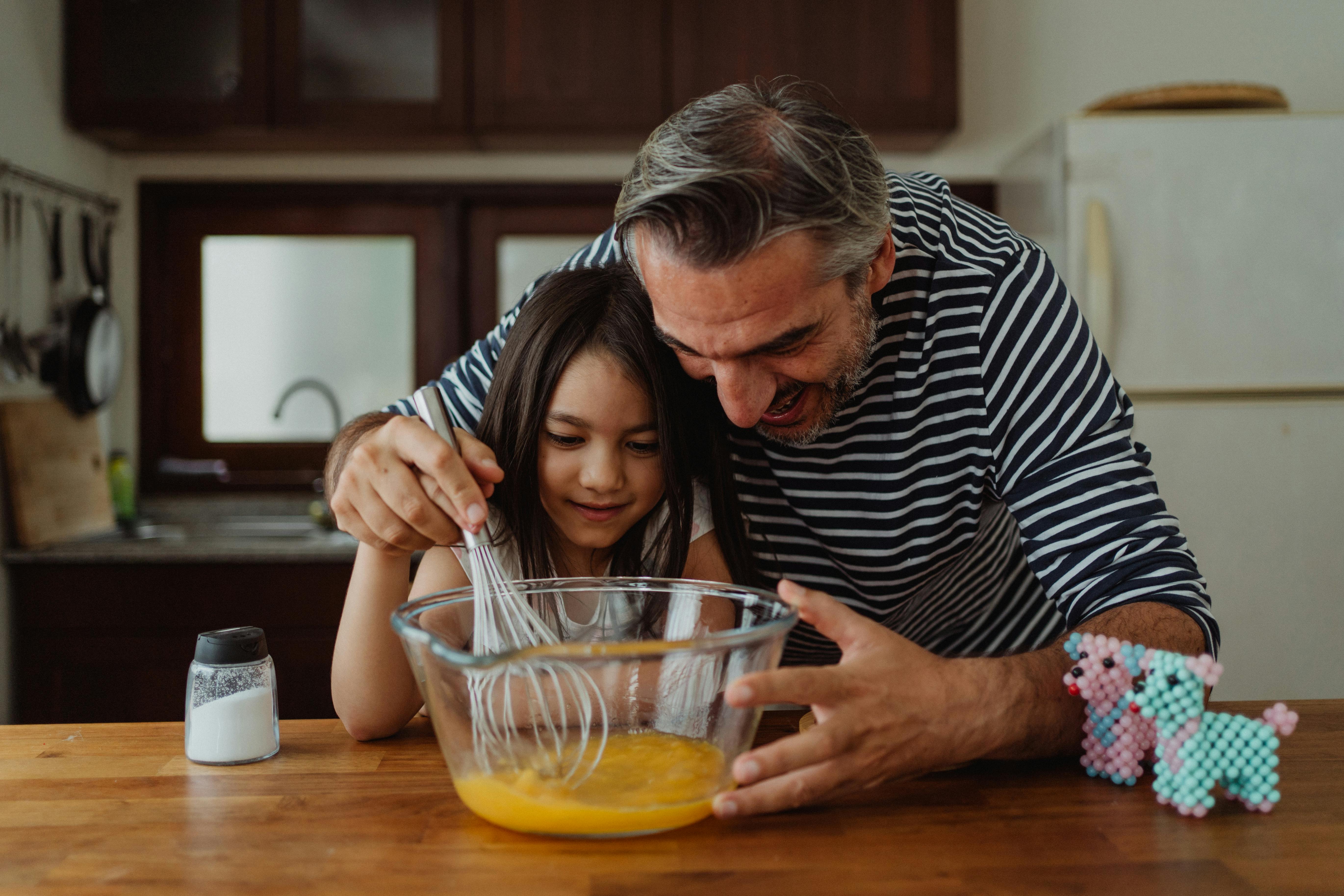 Photo of a Man and a Girl Mixing Ingredients in a Bowl · Free Stock Photo
