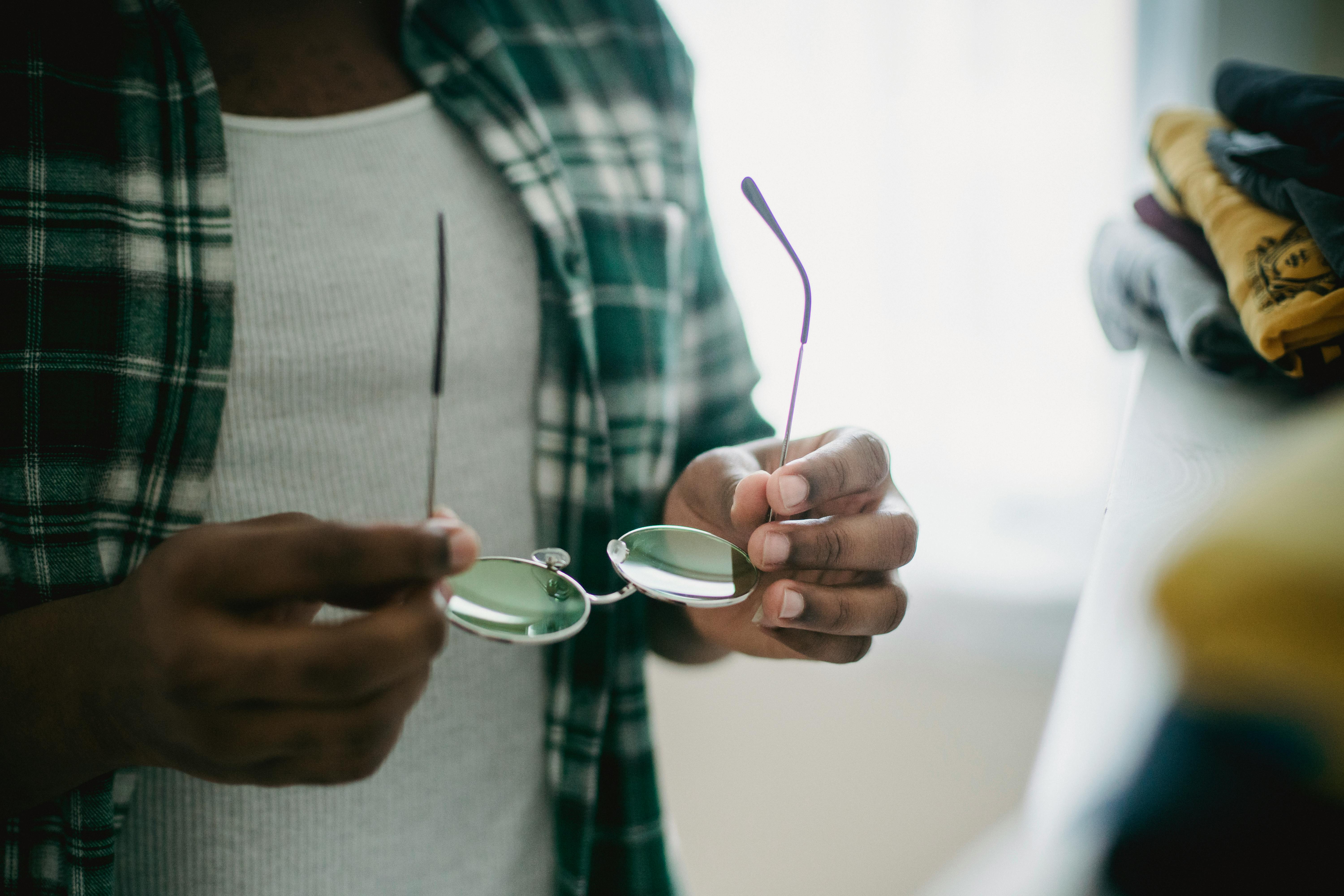 A Person Holding a Pair of Glasses · Free Stock Photo