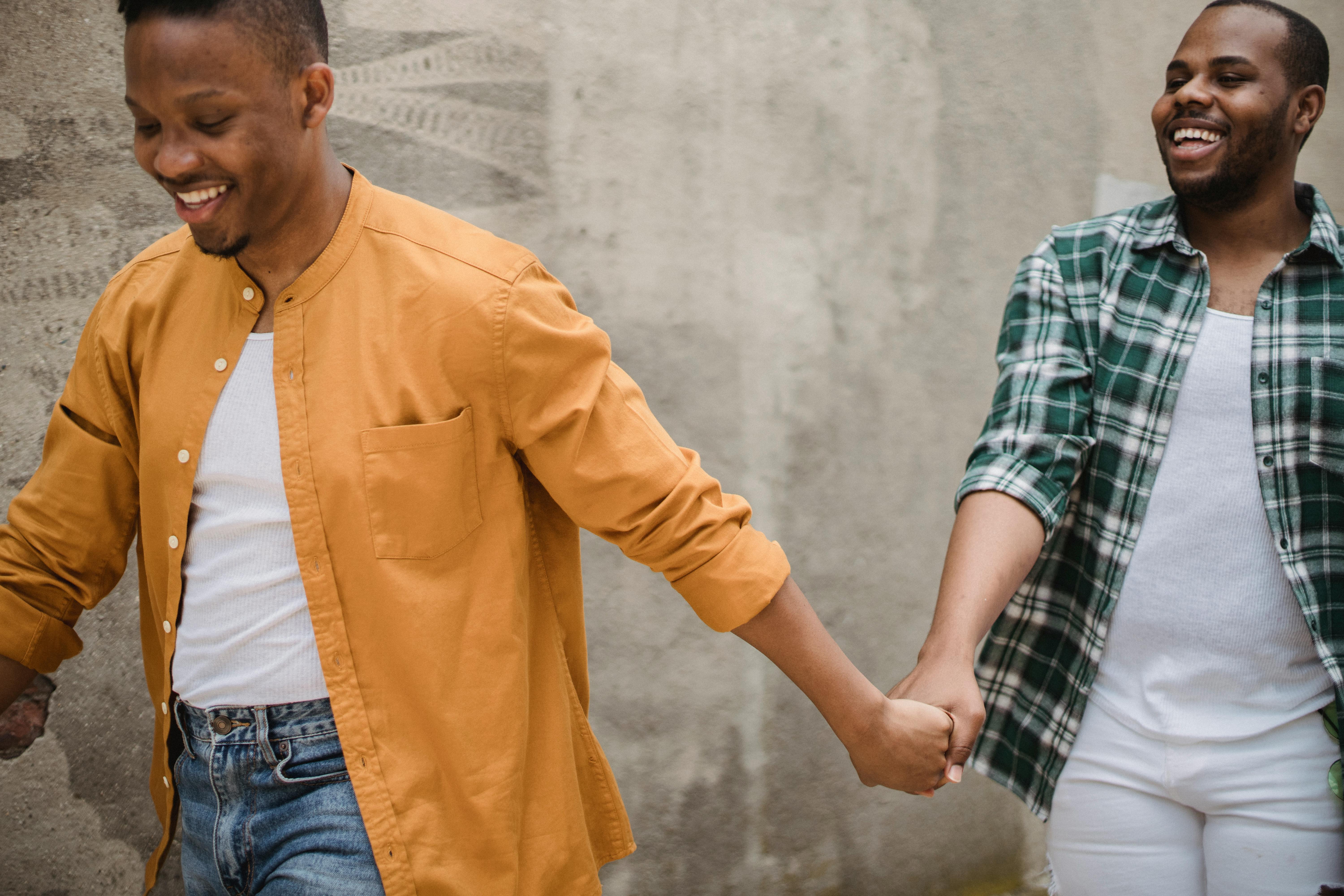 Two Men Holding Hands and Smiling at each other · Free Stock Photo