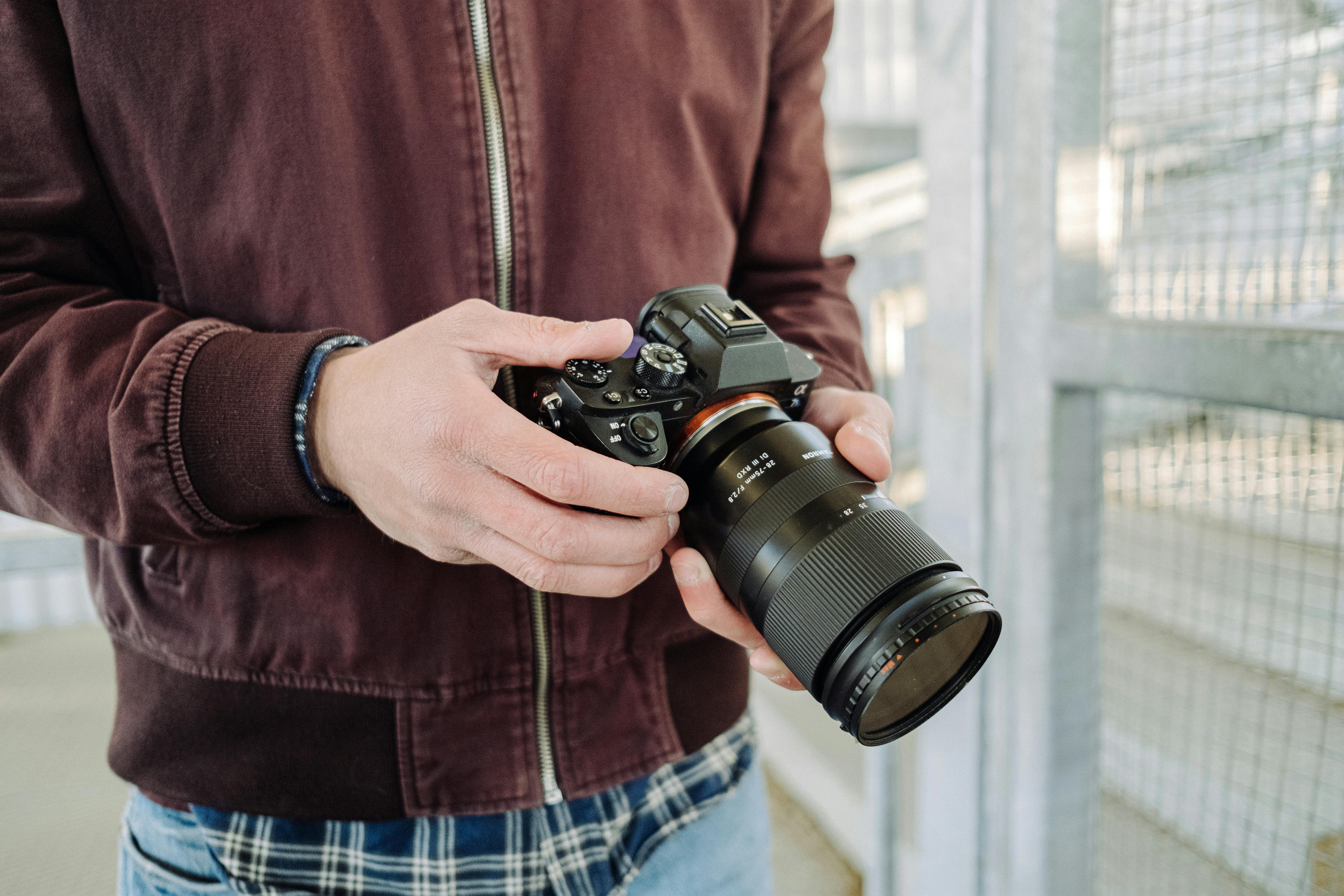 Person in Zip Up Jacket Holding Black Dslr Camera · Free Stock Photo