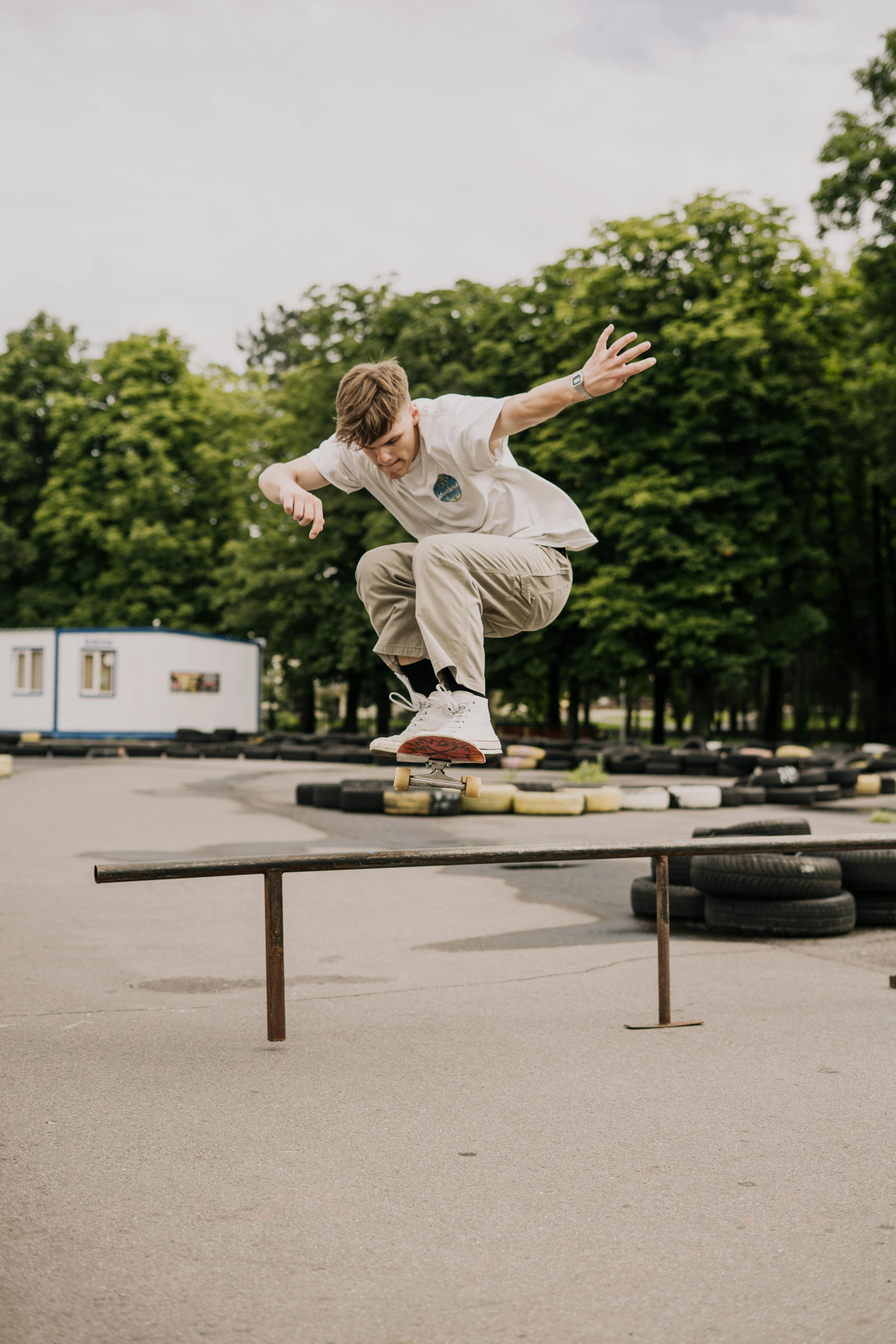 A Young Skater Jumping over a Metal Bar · Free Stock Photo