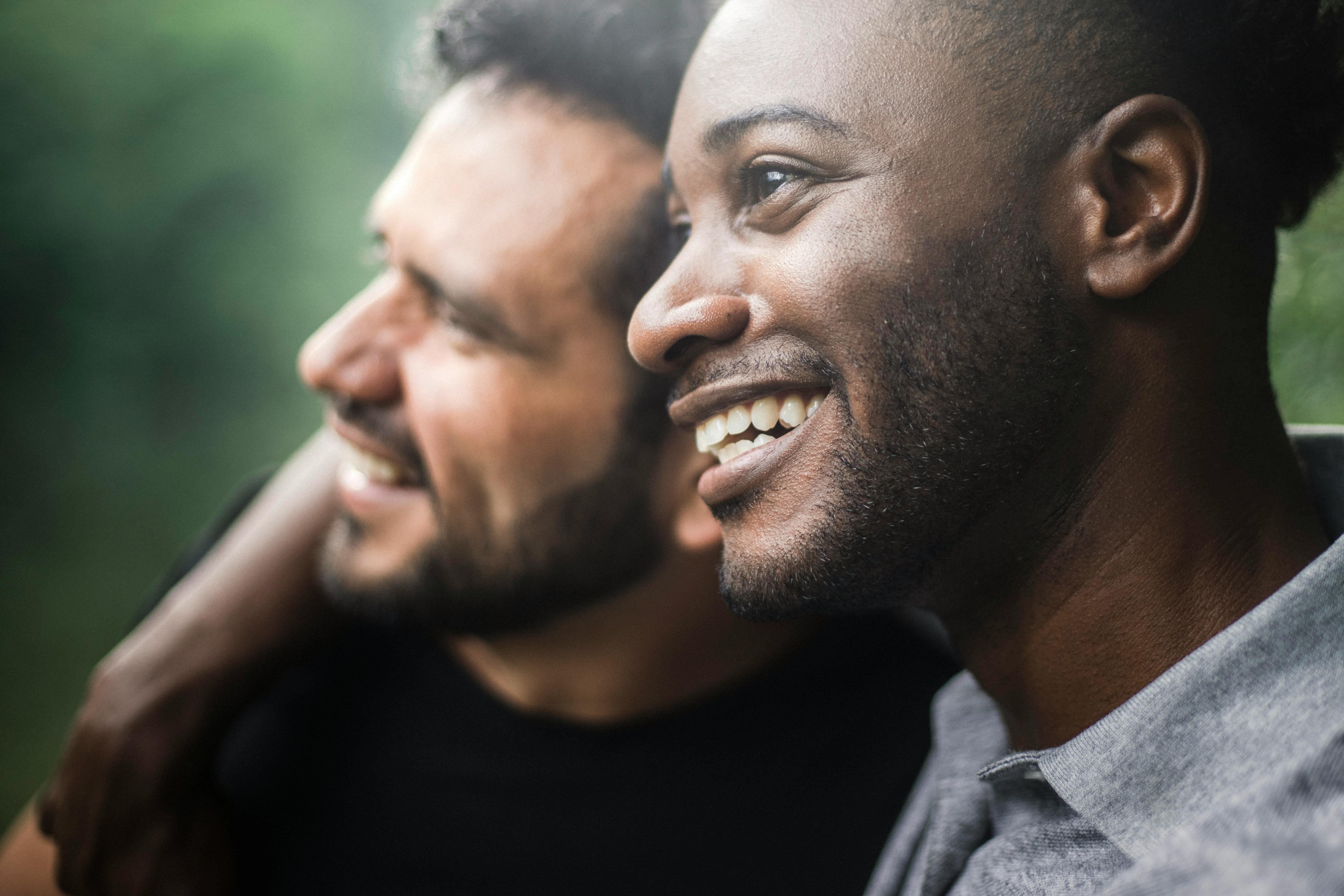 A Man's Arm Wrapped Around Another's Person's Shoulder while Looking ...