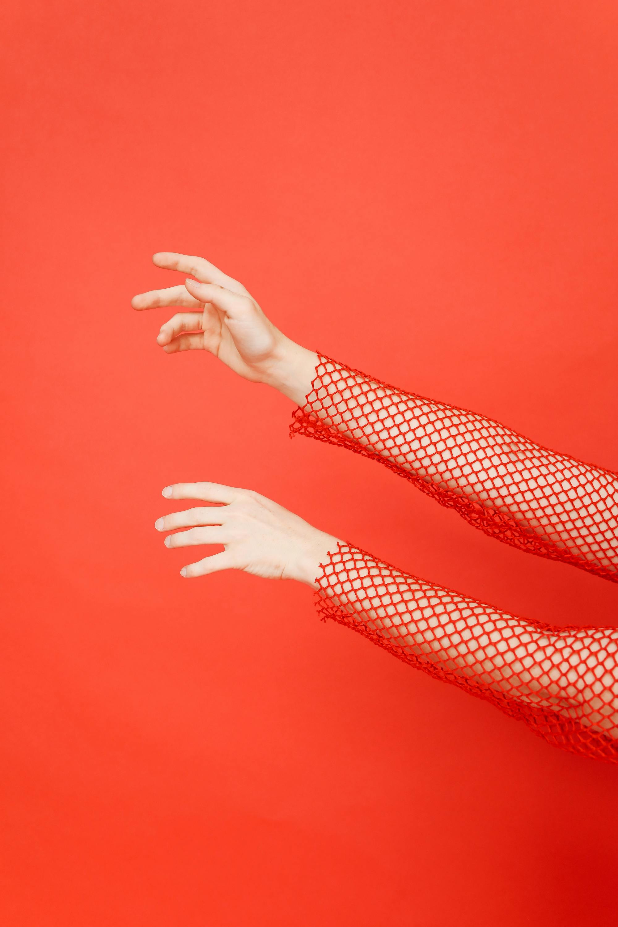 Hands on Red Background Reaching Out · Free Stock Photo