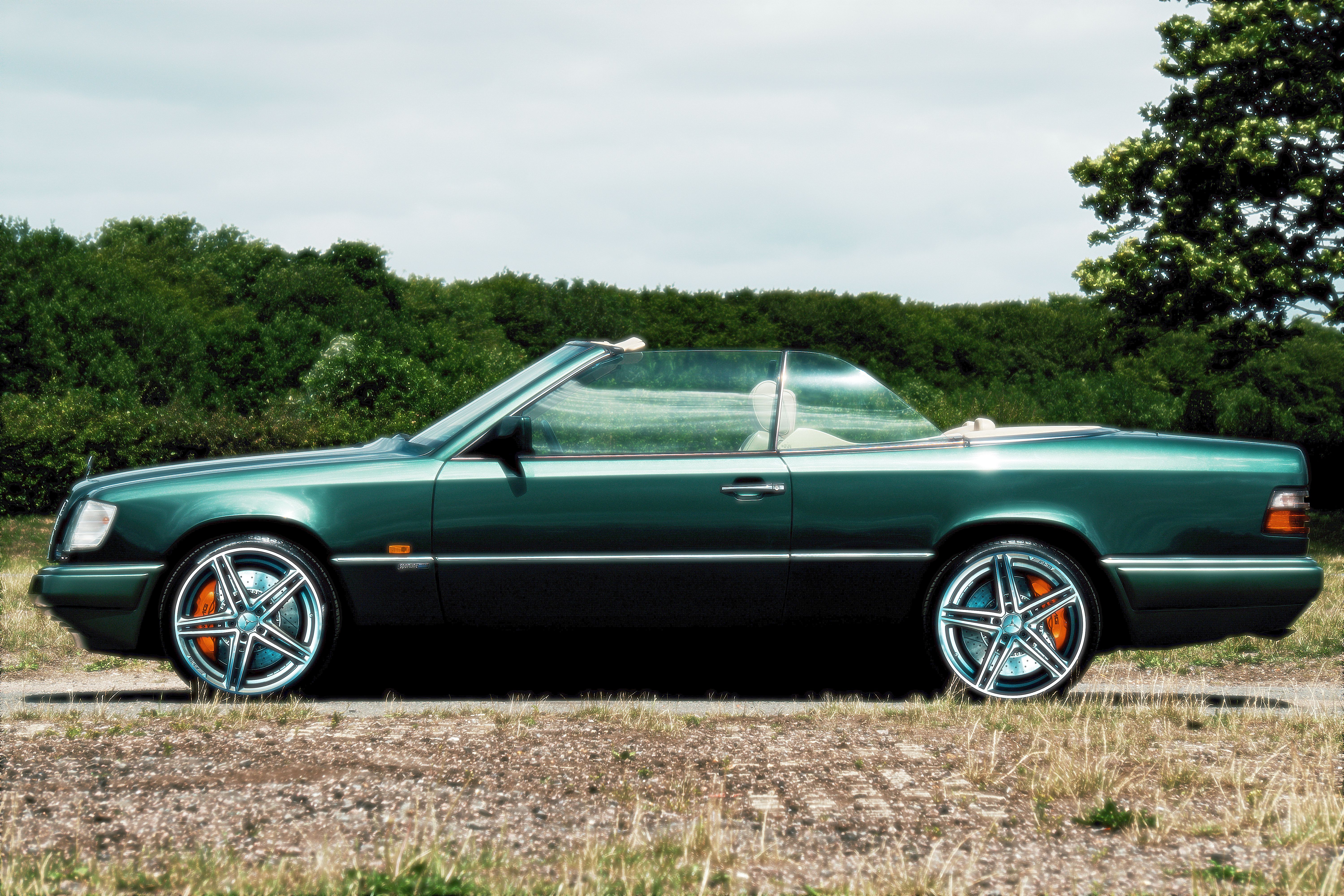 A Green Convertible Car Parked on a Grassy Field · Free Stock Photo