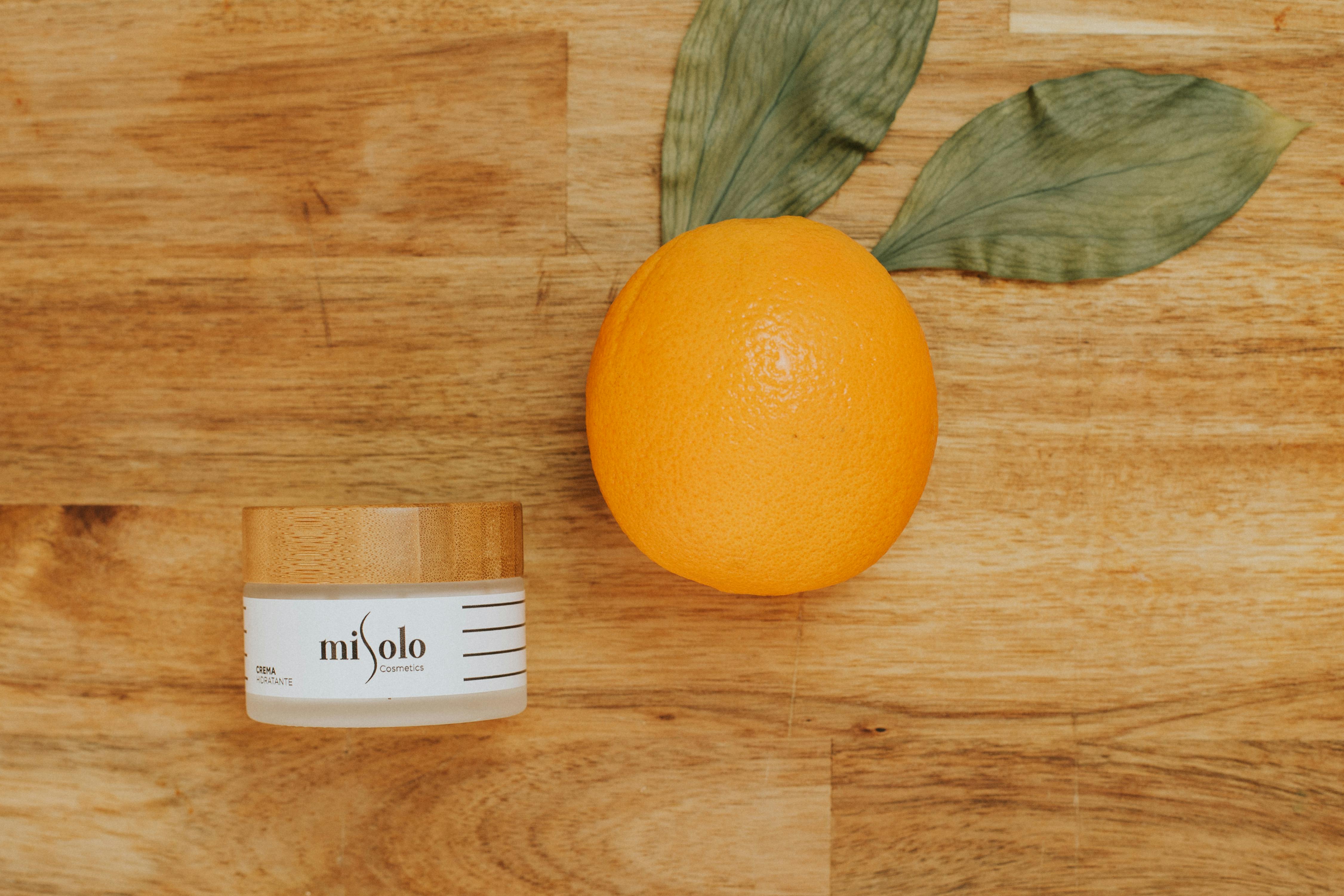 Bottle of Face Cream Lying on Sand by Lake Shore · Free Stock Photo