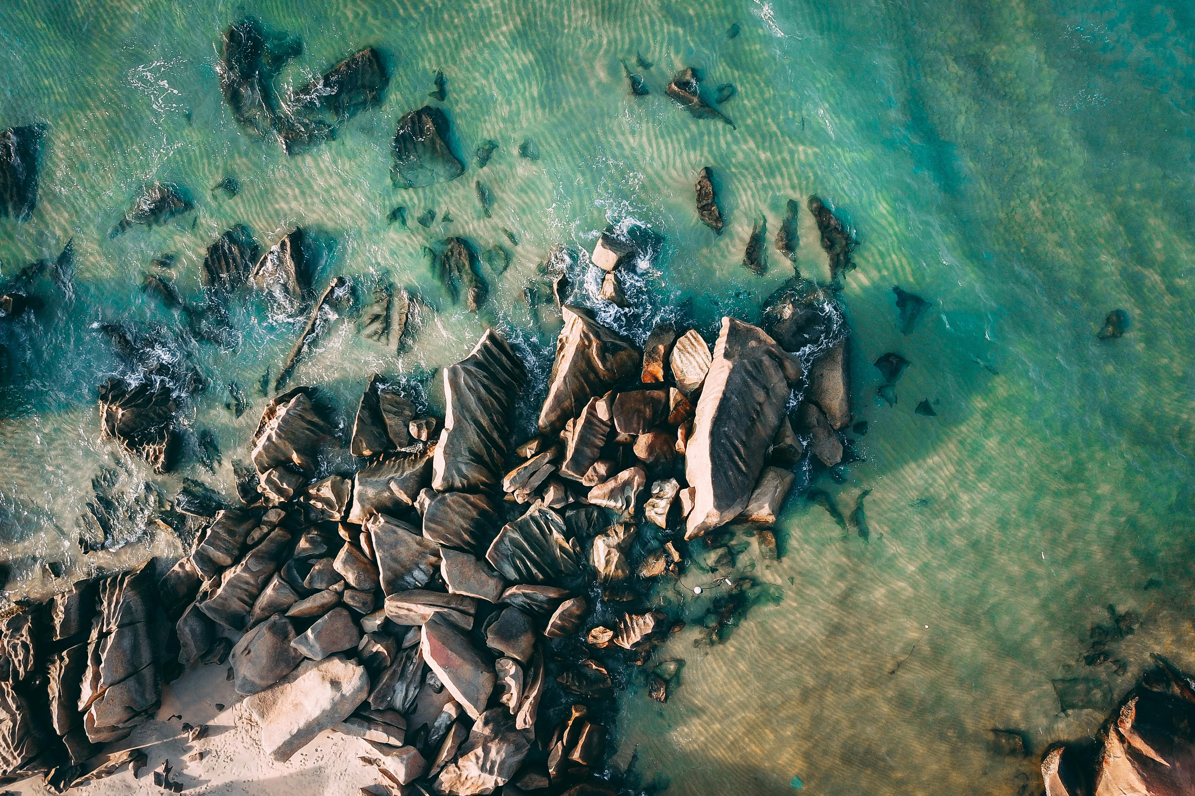Rough rocks near sea with pure water · Free Stock Photo