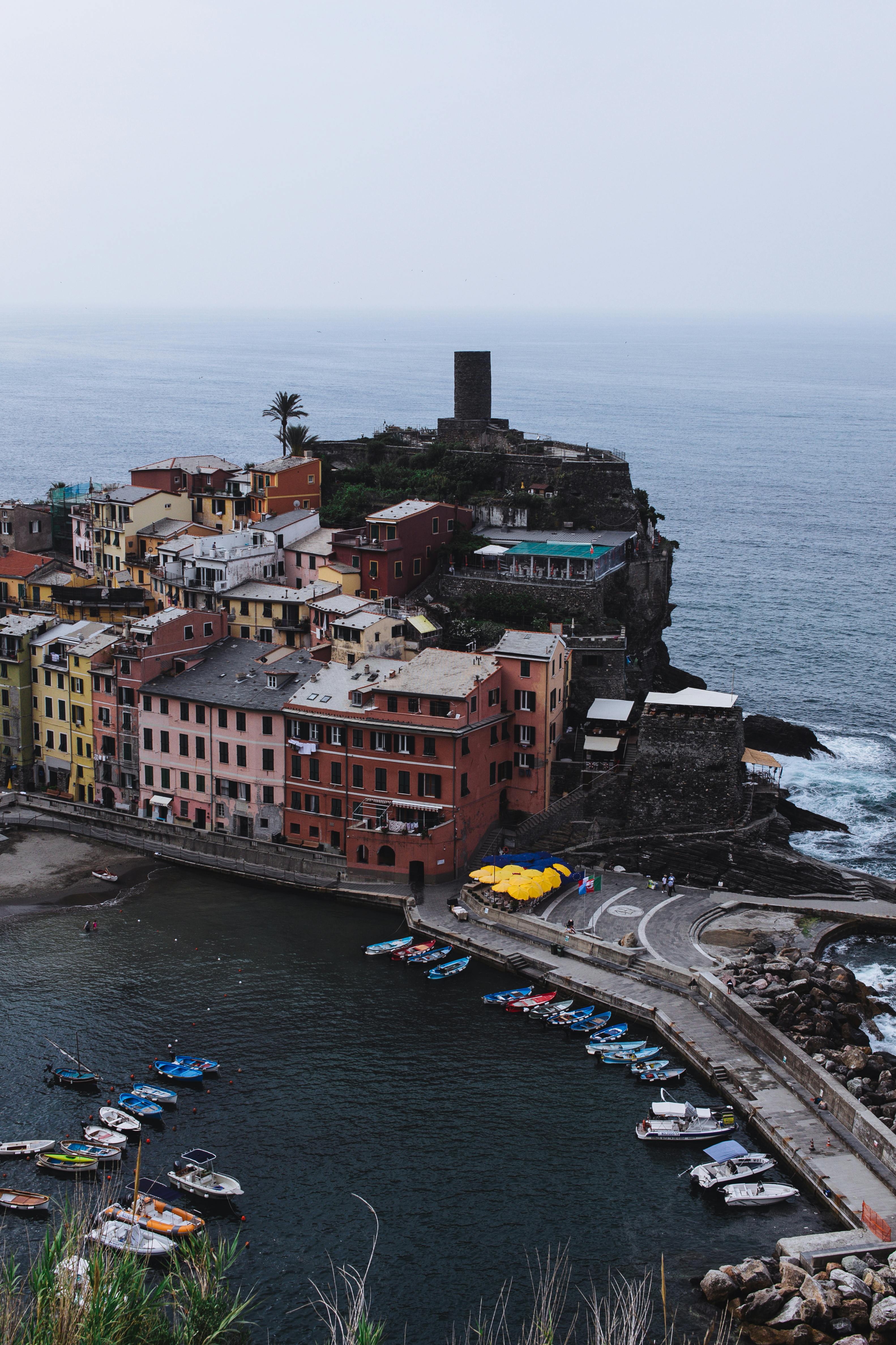 Aged buildings on hill surrounded by water · Free Stock Photo
