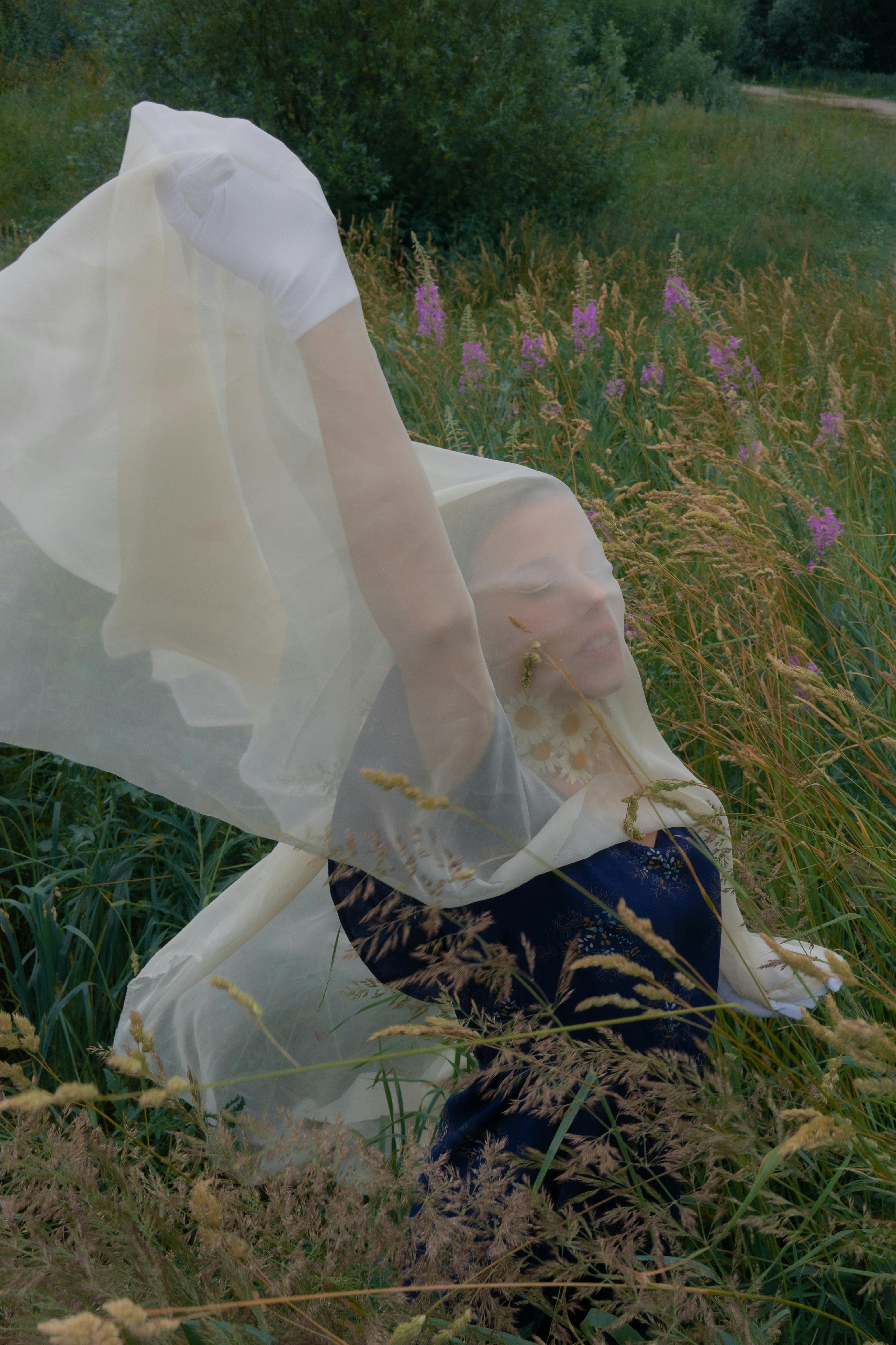 Young woman in flying veil in meadow · Free Stock Photo