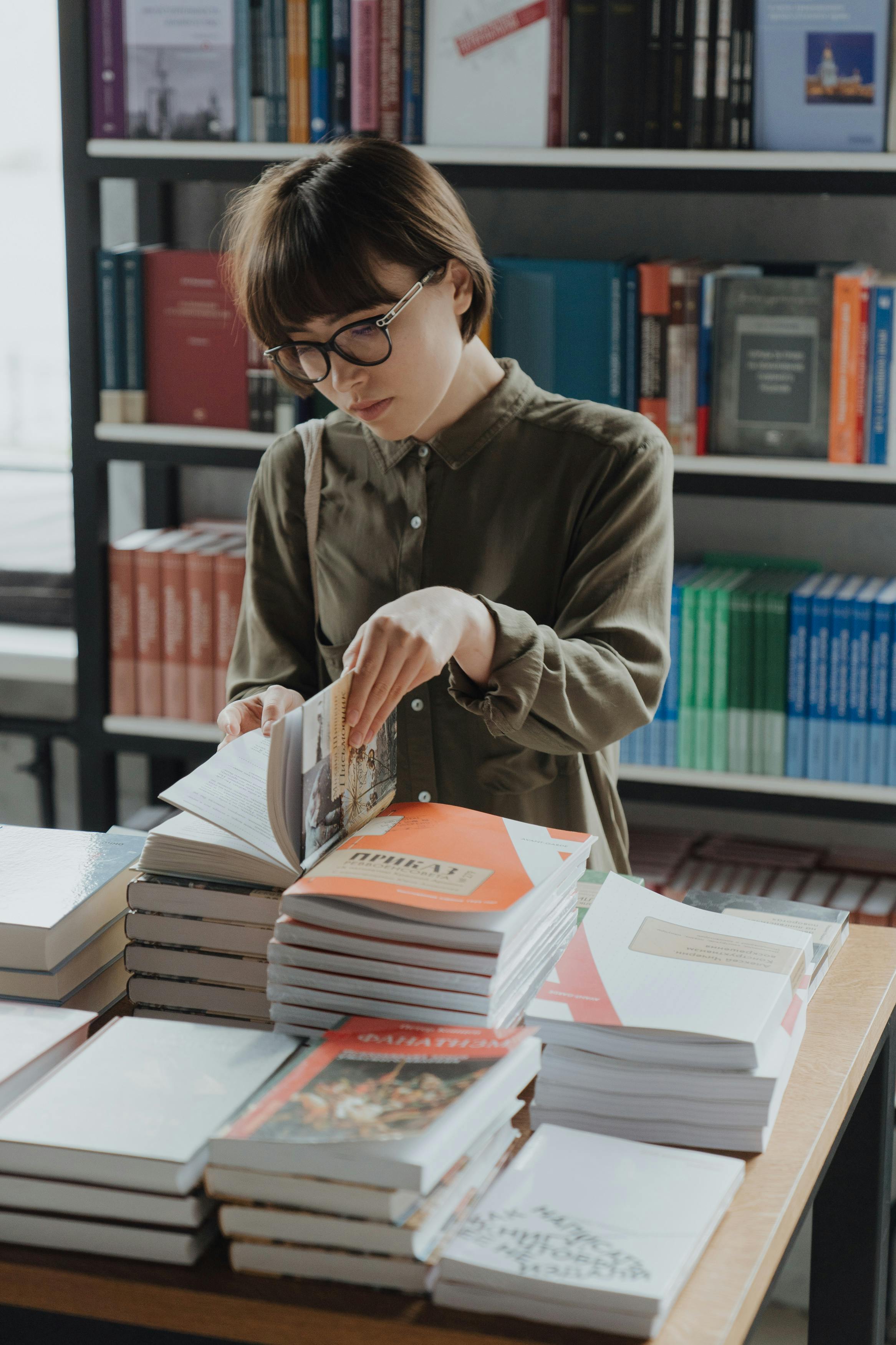 Woman Reading a Book Inside the Bookstore · Free Stock Photo