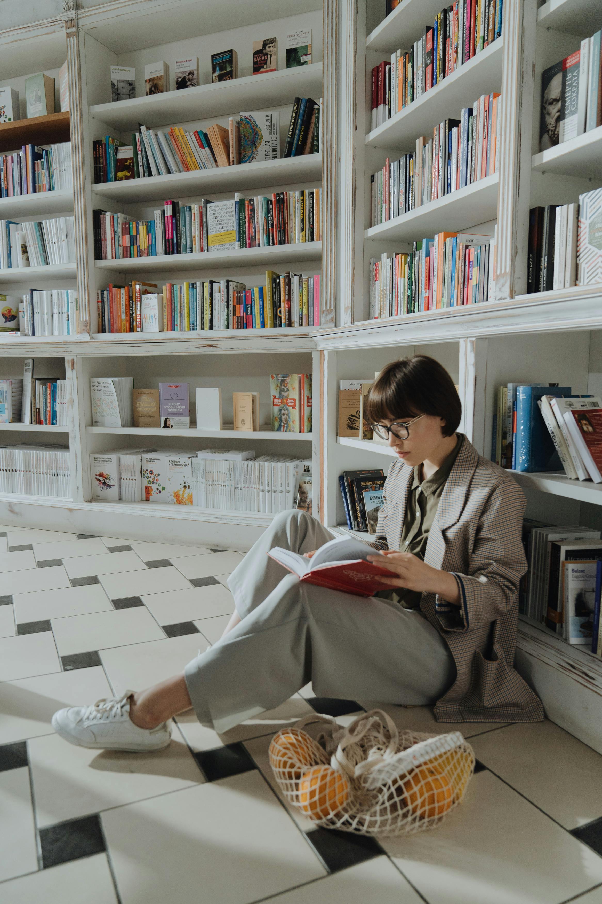Woman in White Robe Sitting on White Bench Reading Book · Free Stock Photo