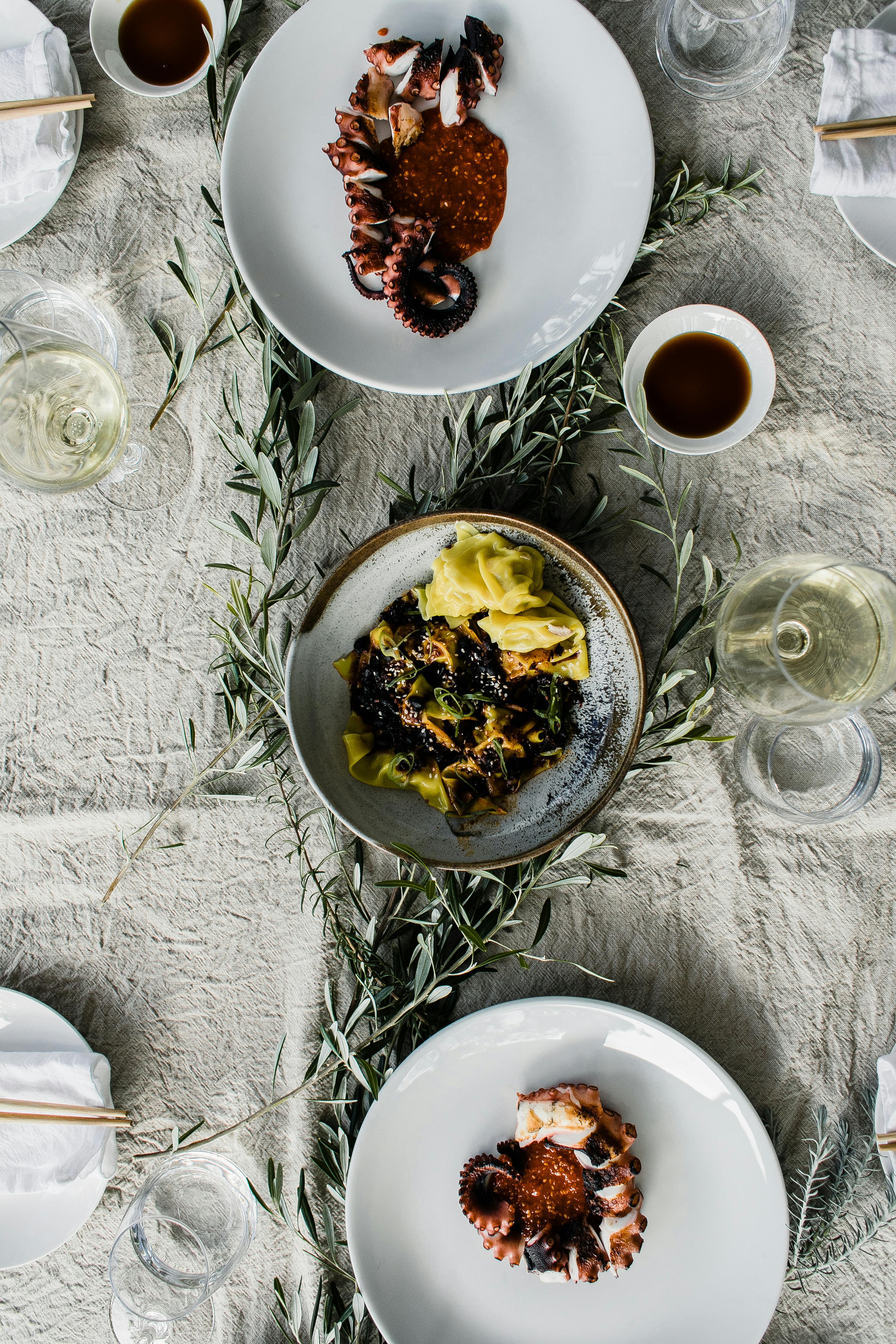 Plates with palatable dishes and glasses of wine · Free Stock Photo