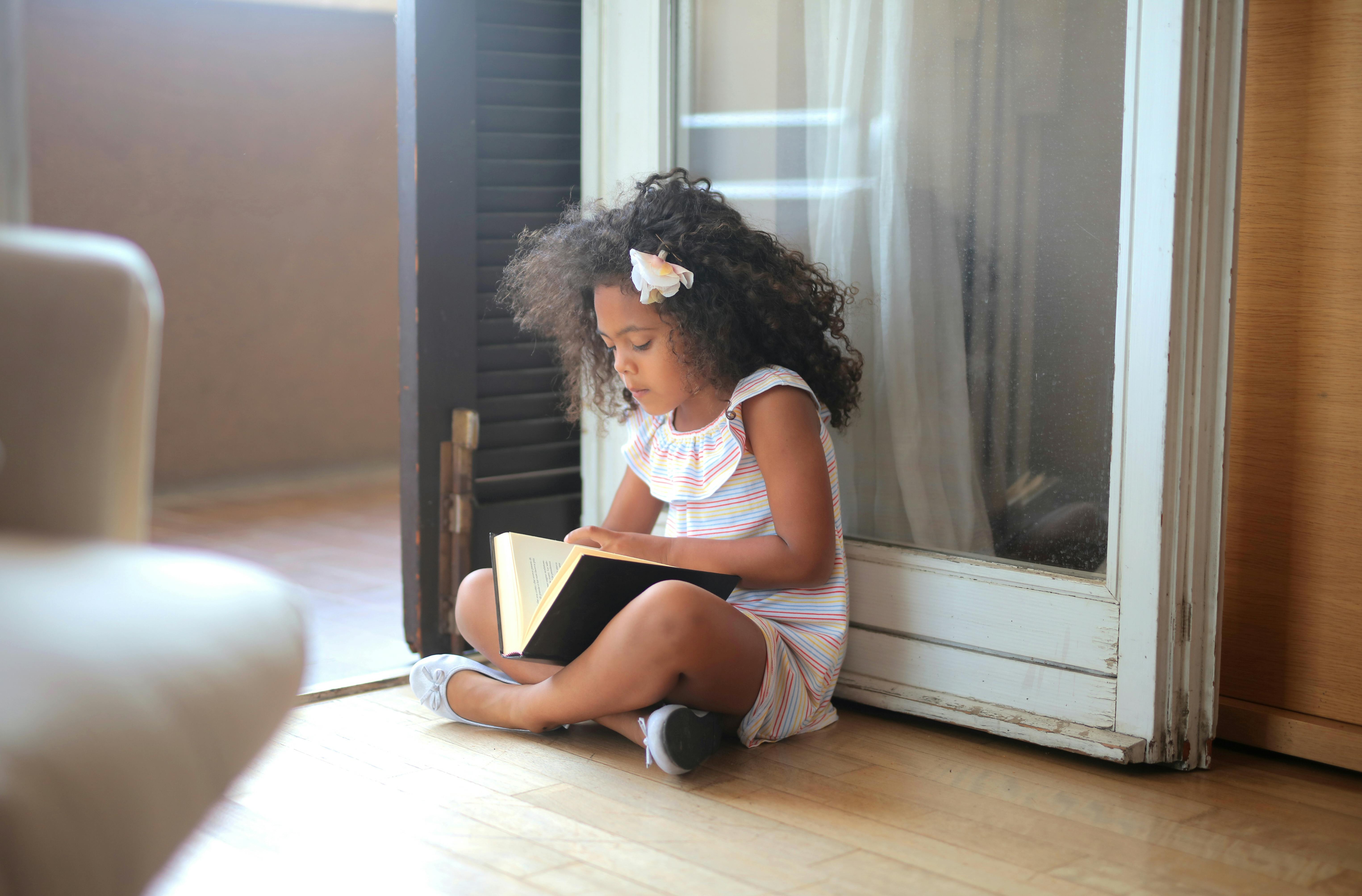 Photo of a Girl Reading a White Notebook · Free Stock Photo