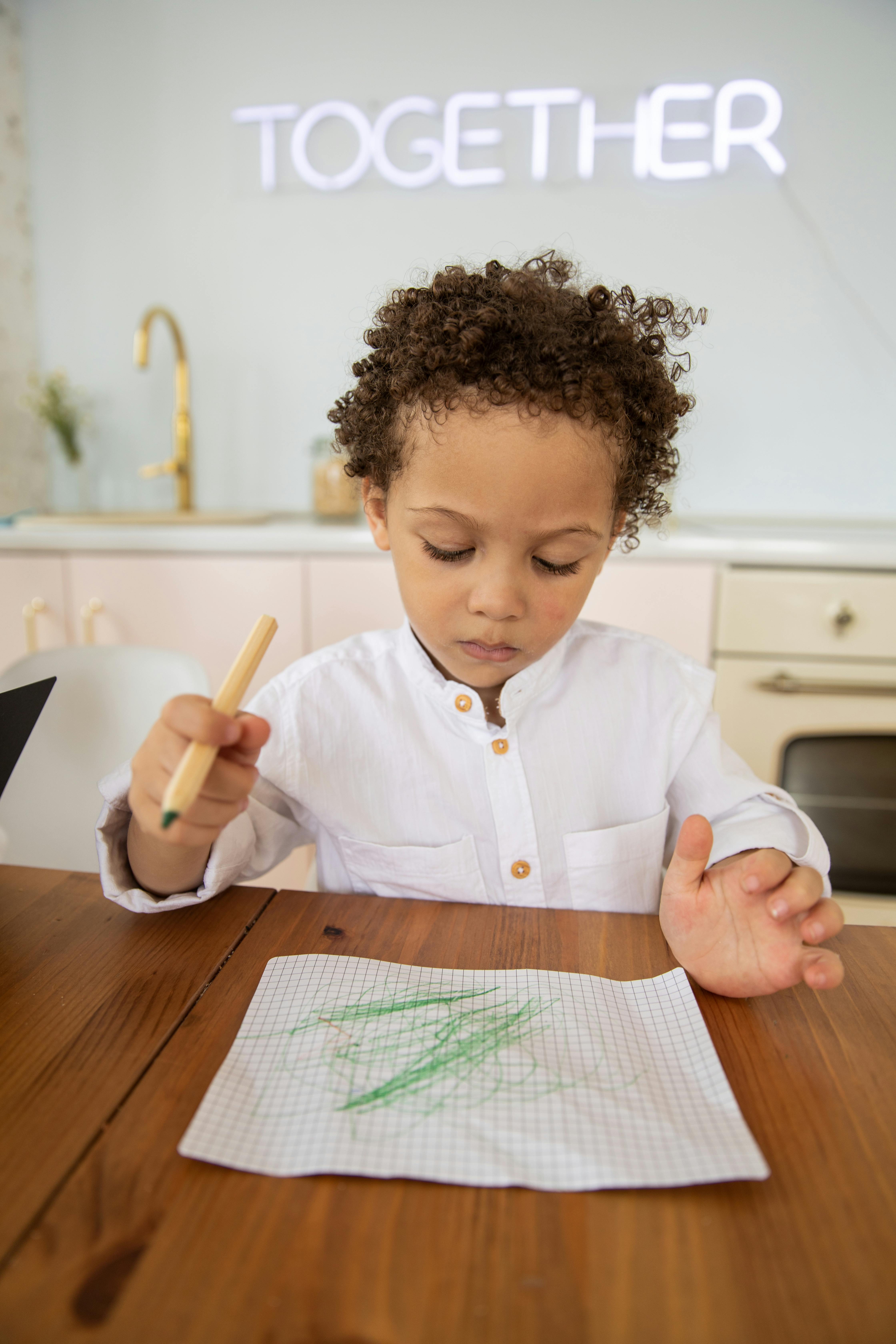 A Boy Drawing on a Piece of Paper · Free Stock Photo