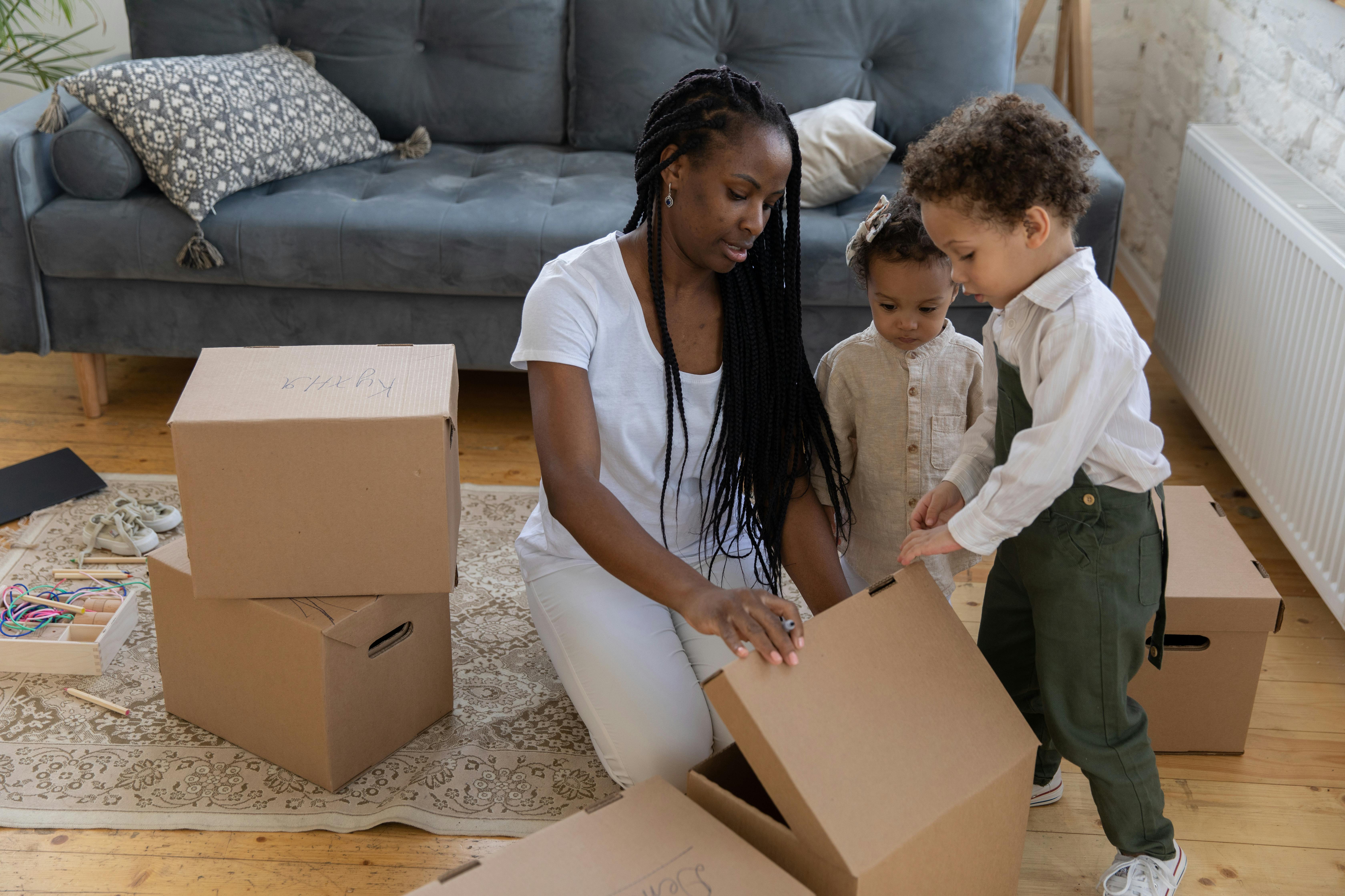Mother Opening Boxes with her Children · Free Stock Photo