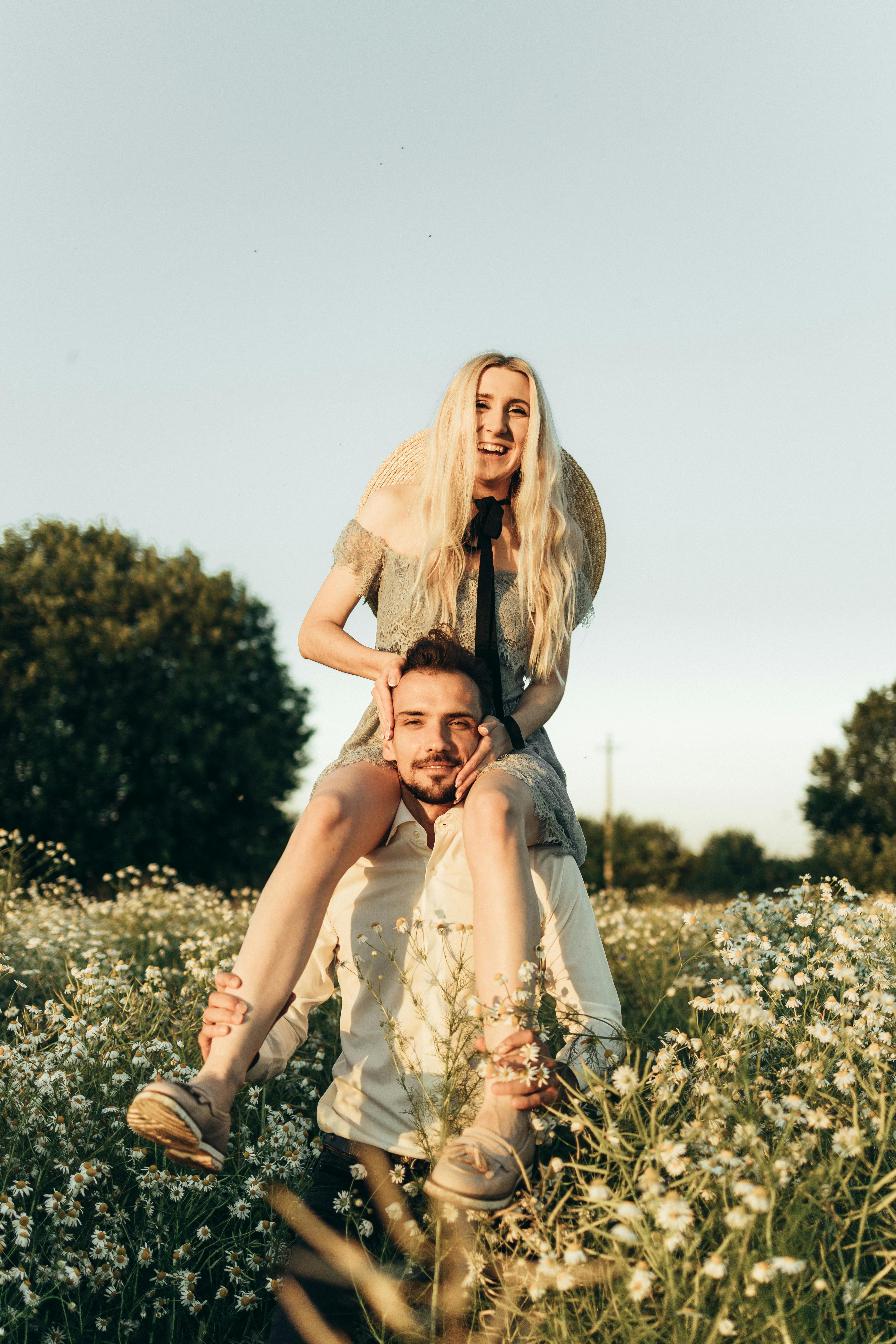 Smiling Woman Riding on Man's Shoulders · Free Stock Photo